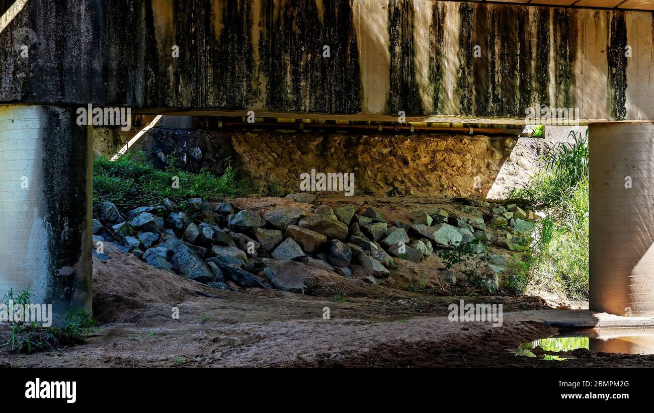Underneath a highway concrete bridge over a creek bank Stock Photo - Alamy