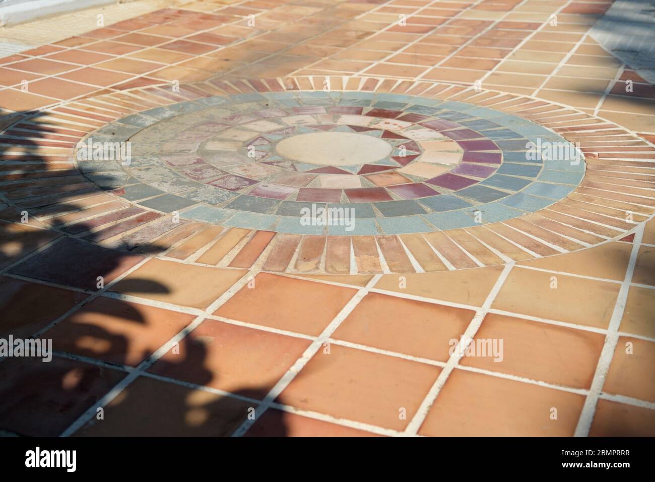 Outdoor mosaic, round tiled pattern on the garden floor Stock Photo - Alamy