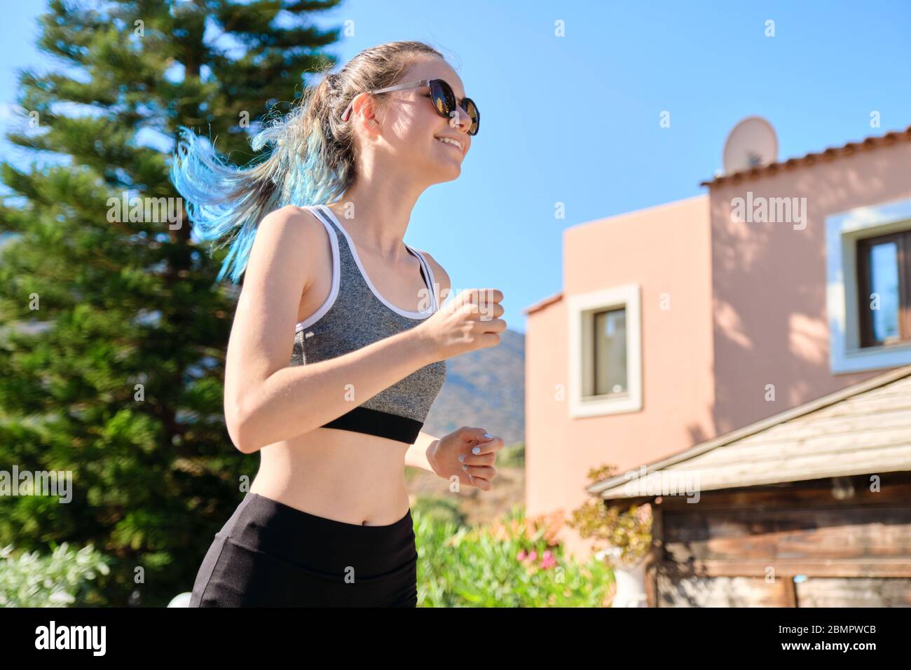 Young fitness girl teenager running on mountain road Stock Photo - Alamy