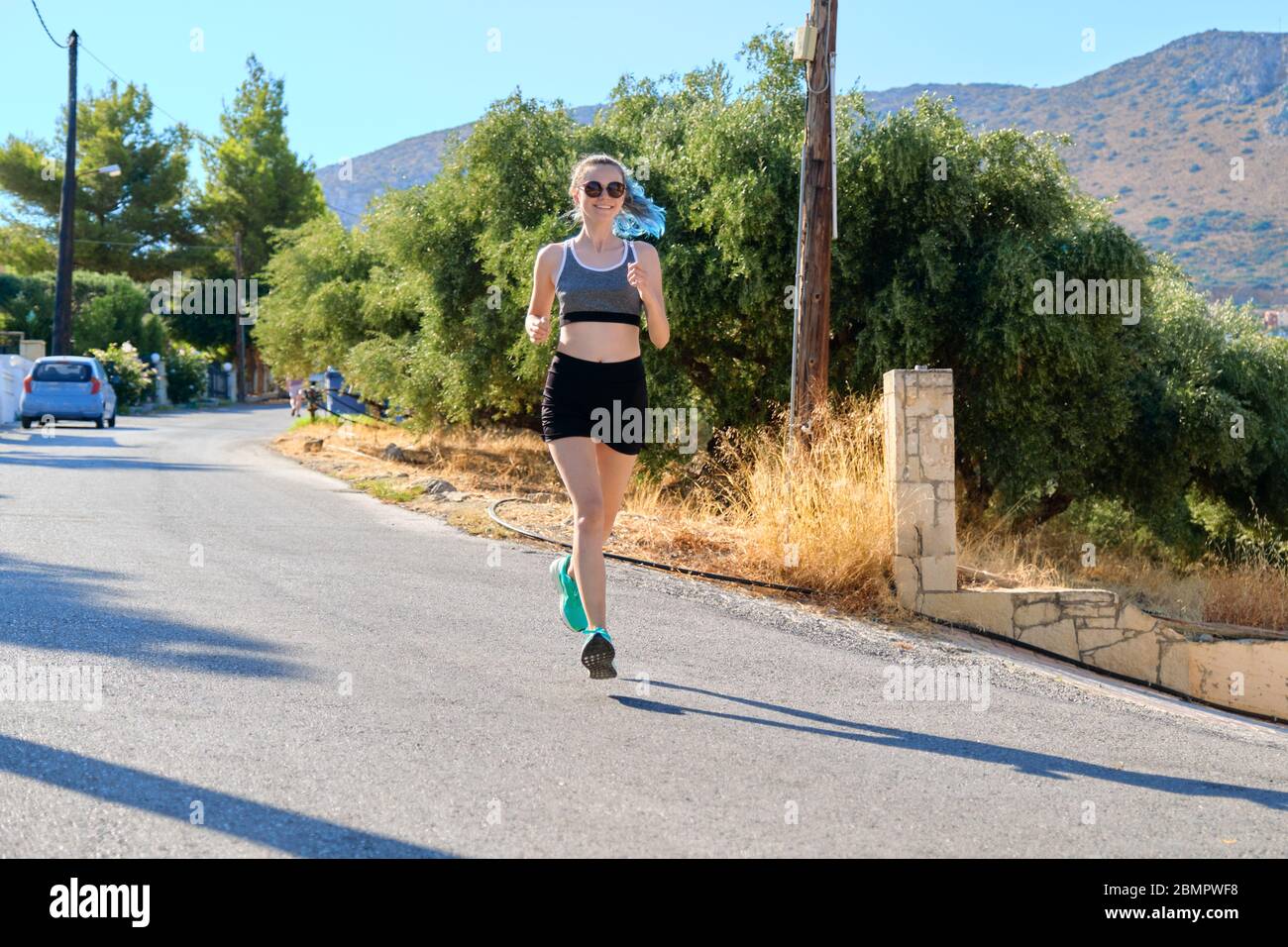 Girl teenager runner, female running on mountain road Stock Photo - Alamy