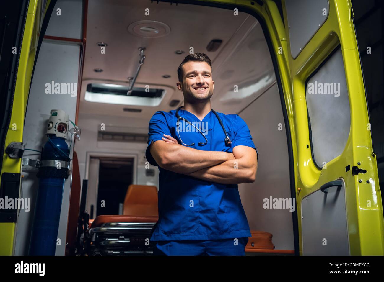 Young doctor standing and smiling in front of an an ambulance car Stock ...