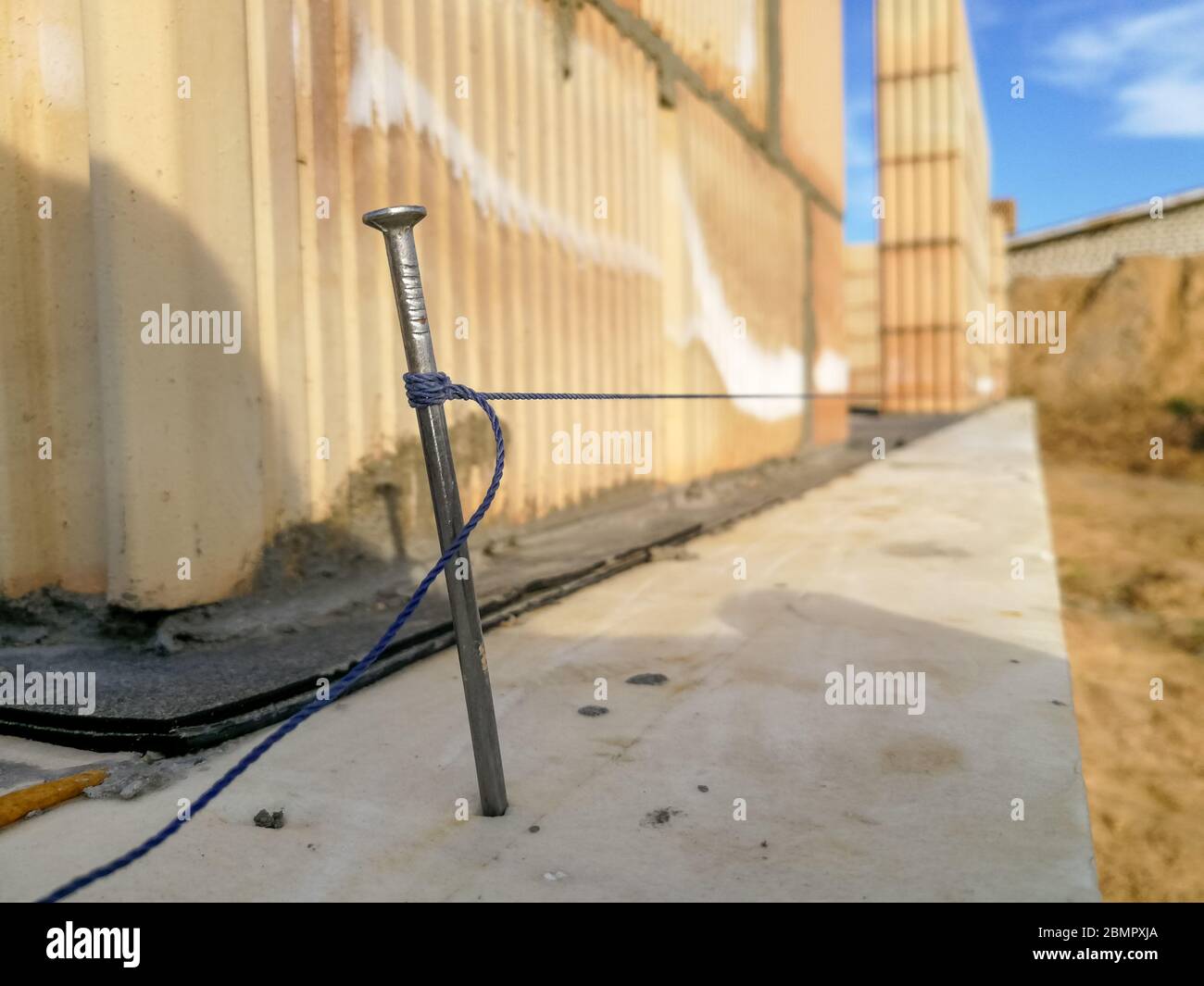 Nail and string for ceramic building block construction leveling in ...