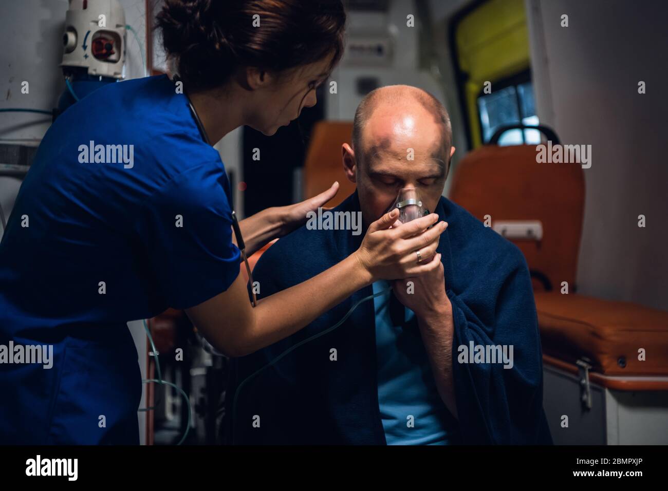 Paramedic pressing an oxygen mask to an injured man's face Stock Photo ...