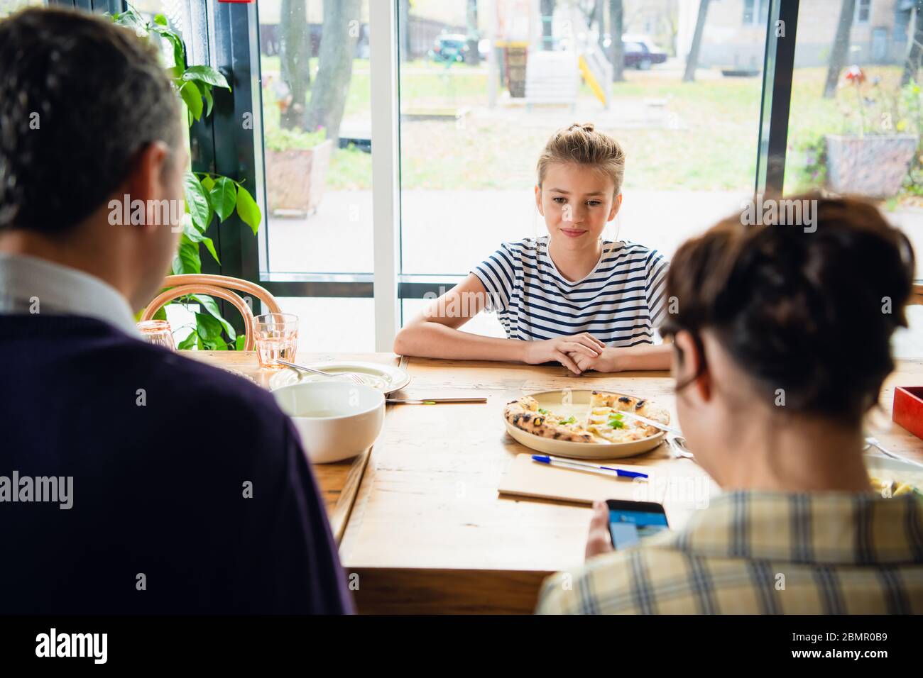 Daughter chatting with her parents at the table Stock Photo - Alamy