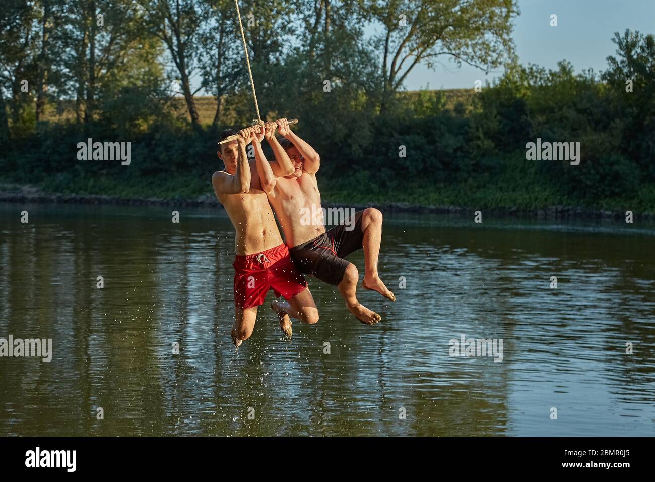 Guys jumping in a river Stock Photo - Alamy