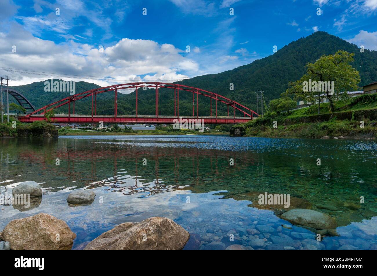 Red bridge and river in the mountain valley. Japanese countryside ...