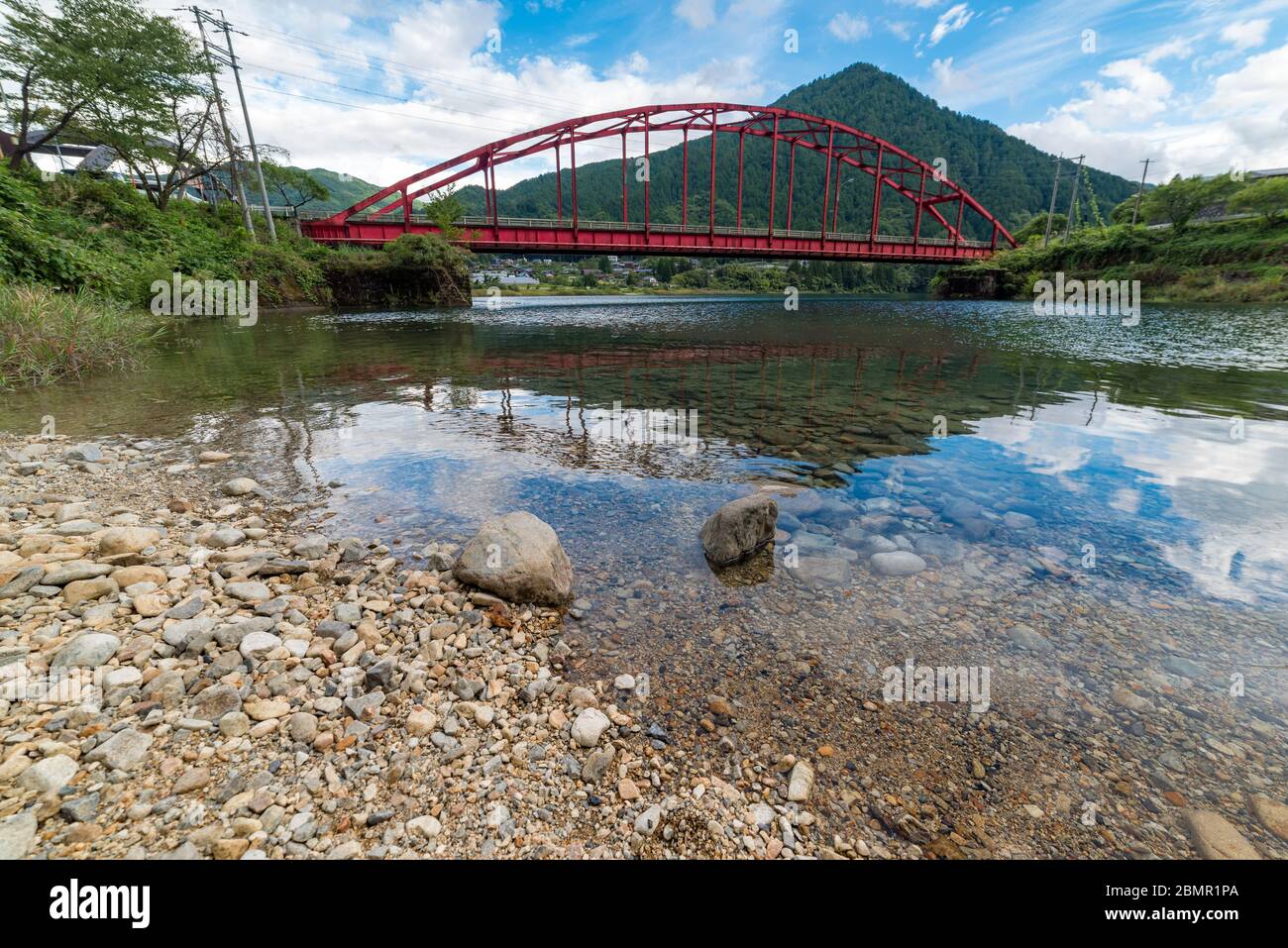 Red bridge and river in the mountain valley. Japanese countryside ...