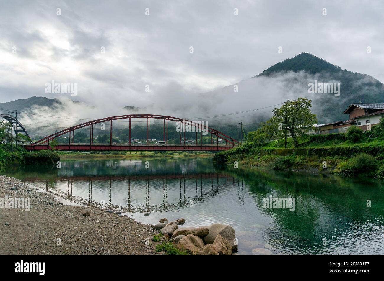Red bridge and river in the mountain valley. Japanese countryside ...