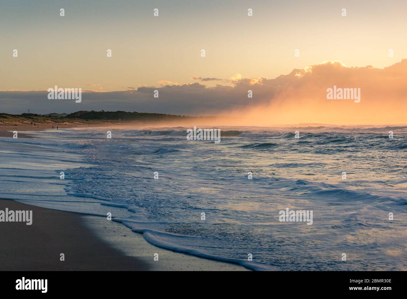Sunrise at sandy beach with mild waves and gold colored fog. Summer ...