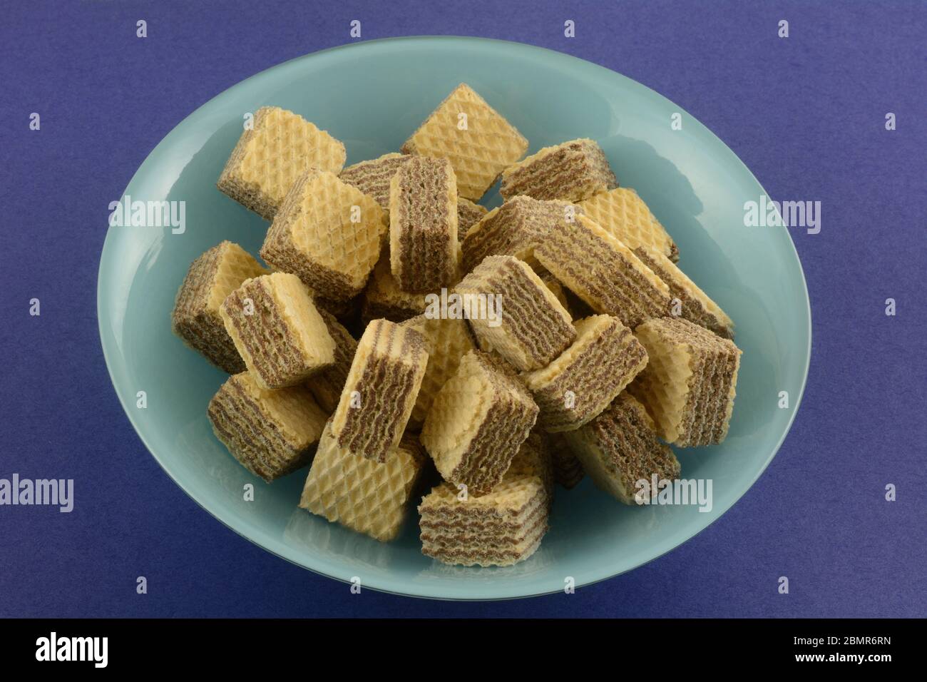 Bite size chocolate hazelnut wafer cookies in blue bowl on blue ...