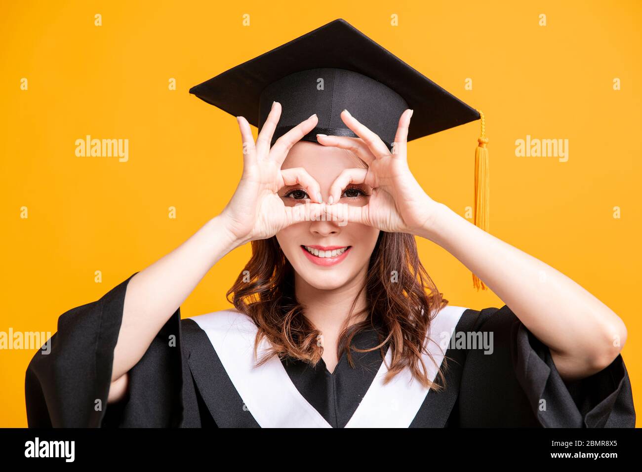 happy young woman in graduation gowns with looking gesture Stock Photo ...
