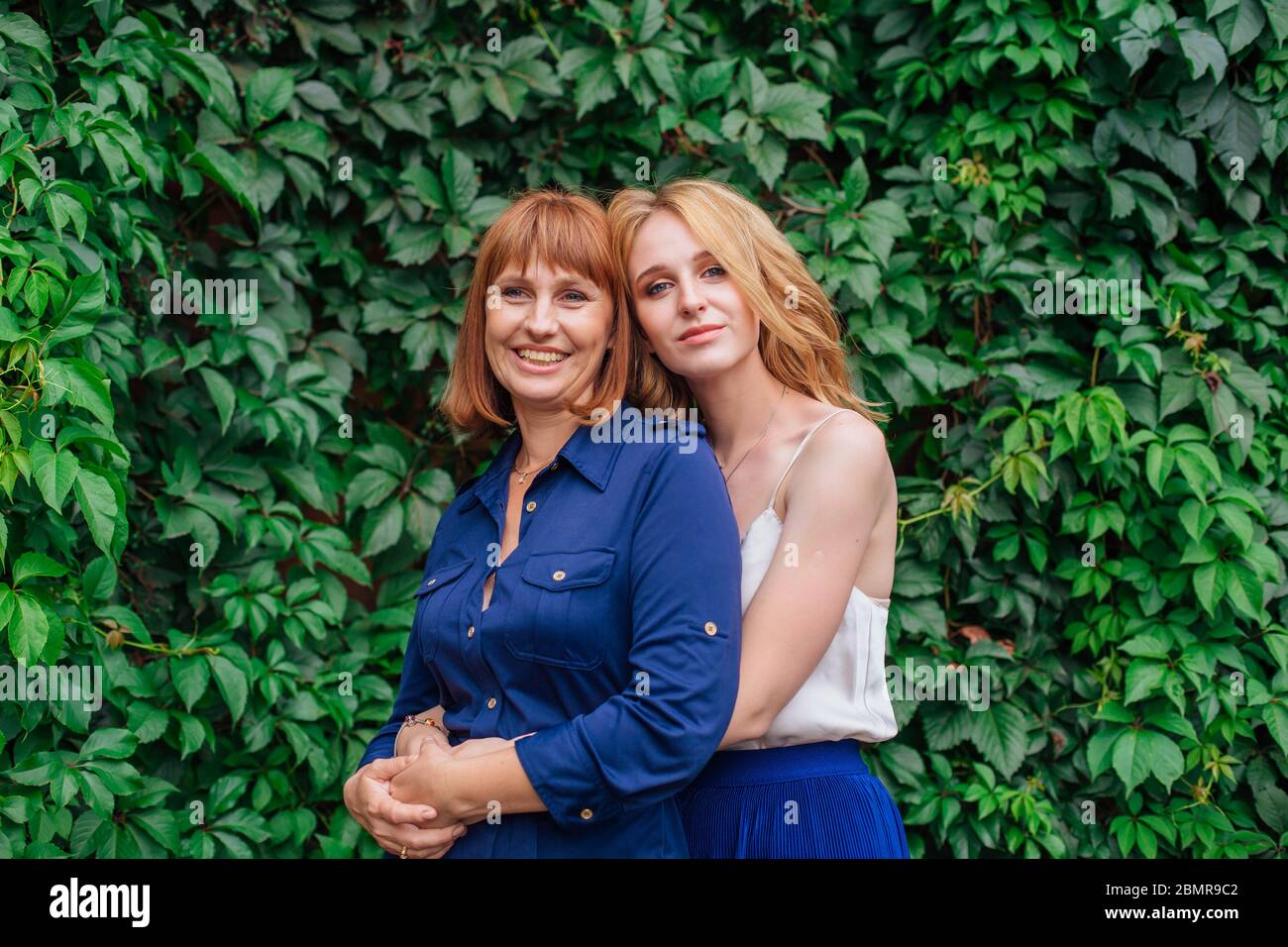 Beautiful mother and her grown up daughter hugging each other on a ...
