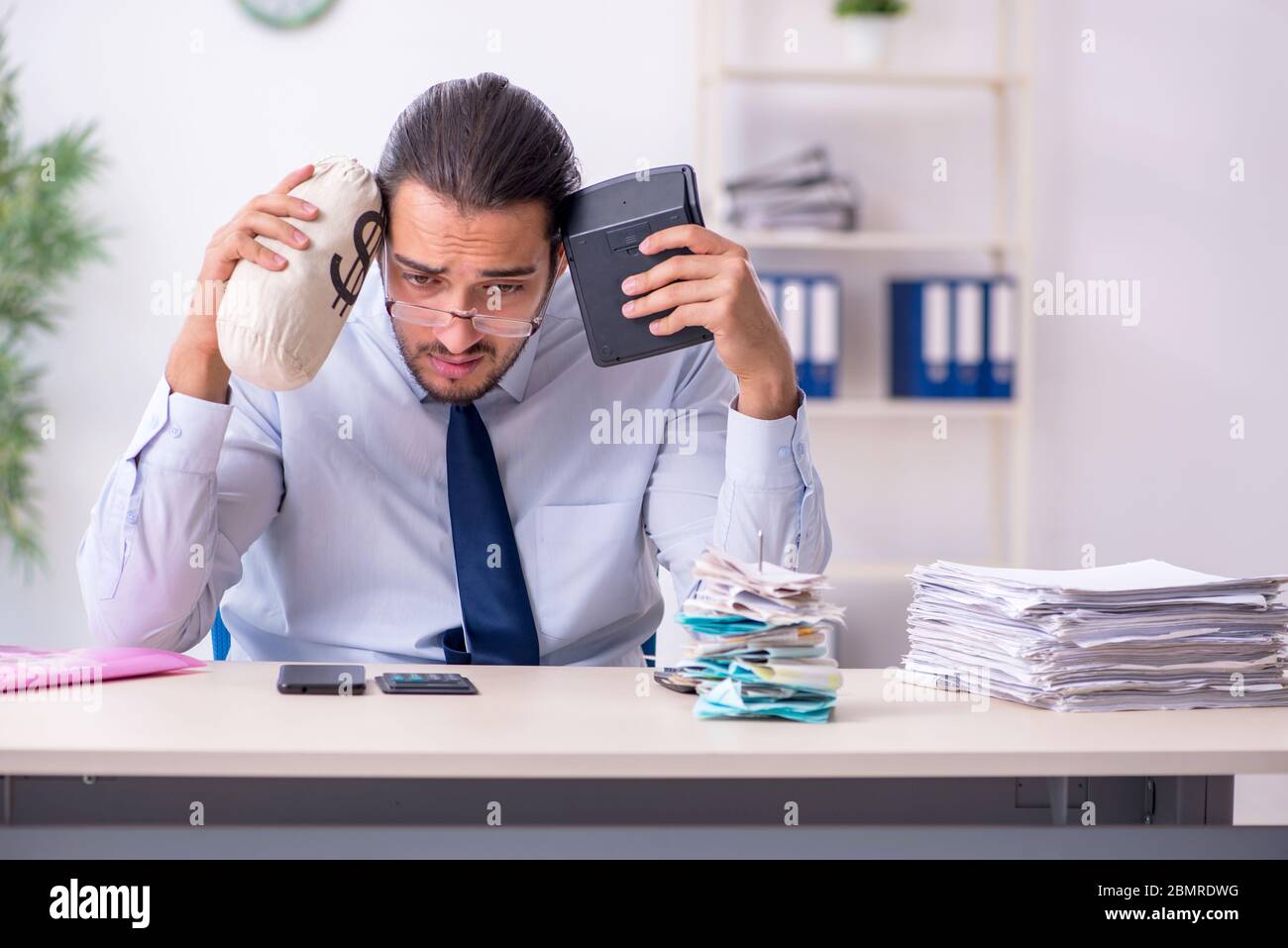 Young employee in budget planning concept Stock Photo - Alamy