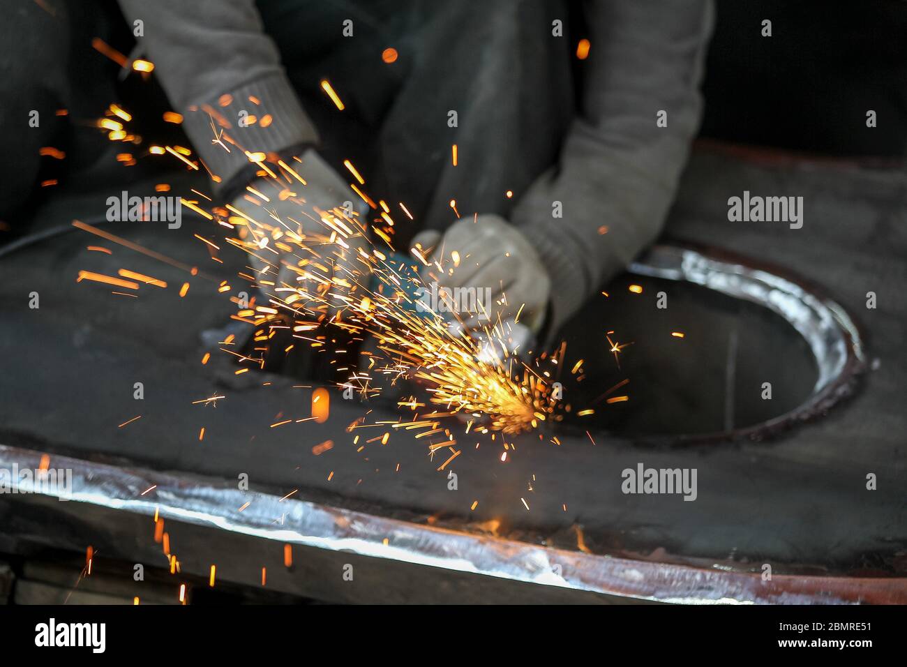 Master grind metal a grinder sparks Stock Photo - Alamy