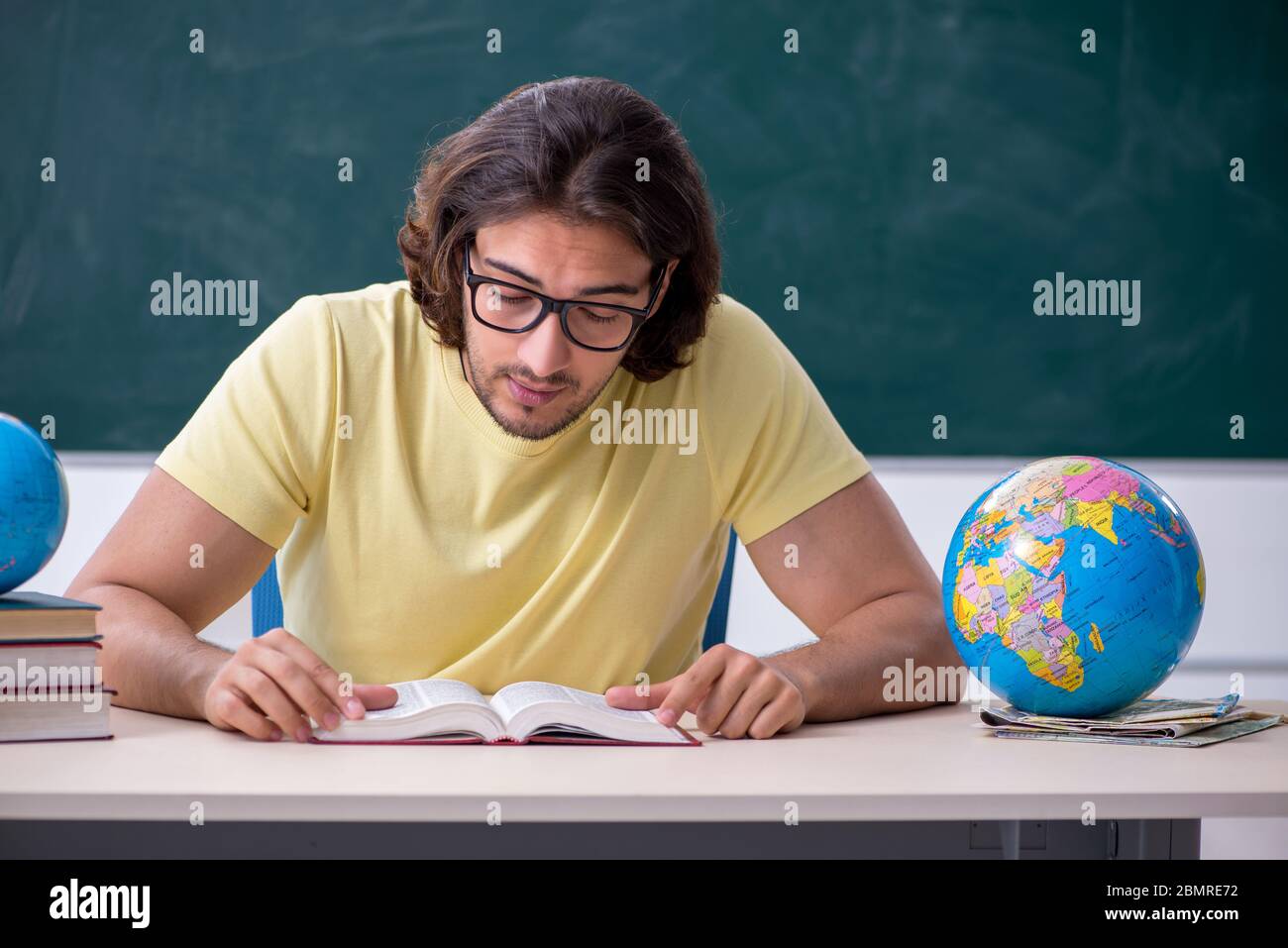 Young geography teacher in front of blackboard Stock Photo - Alamy