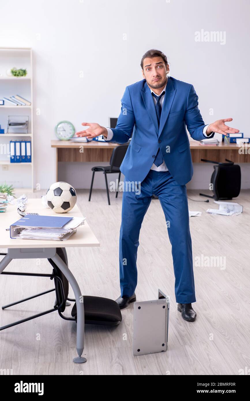 Young employee playing football in the office Stock Photo - Alamy