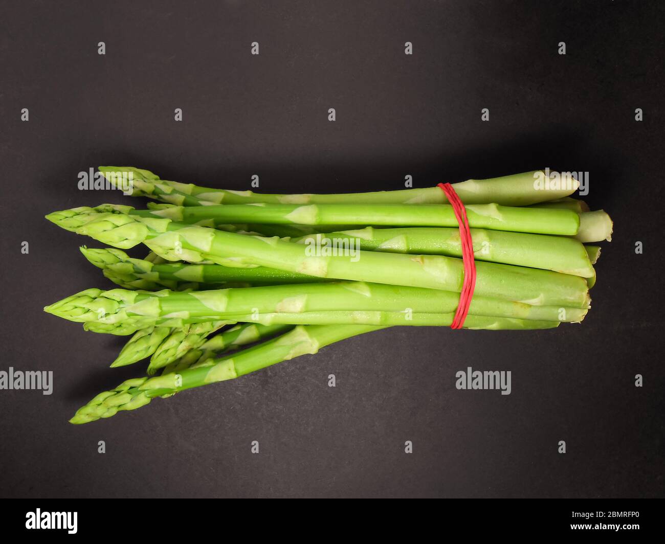 Bunch of raw asparagus. Fresh green asparagus on a black background ...