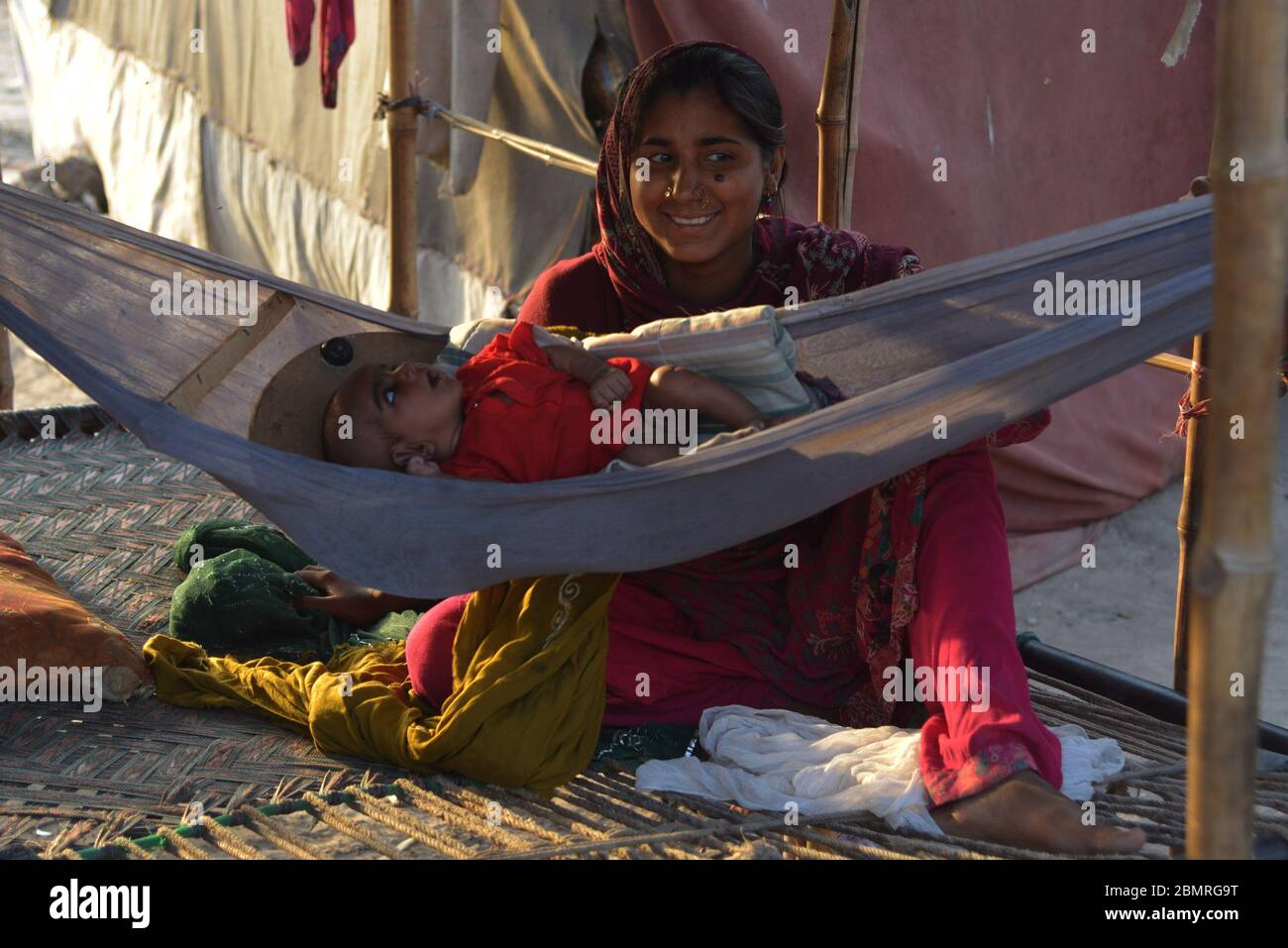 Lahore, Pakistan. 10th May, 2020. Pakistani mother is playing and ...