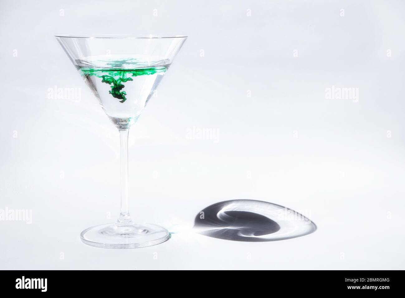 Single bright green drop of color separated from water in crystal clear ...