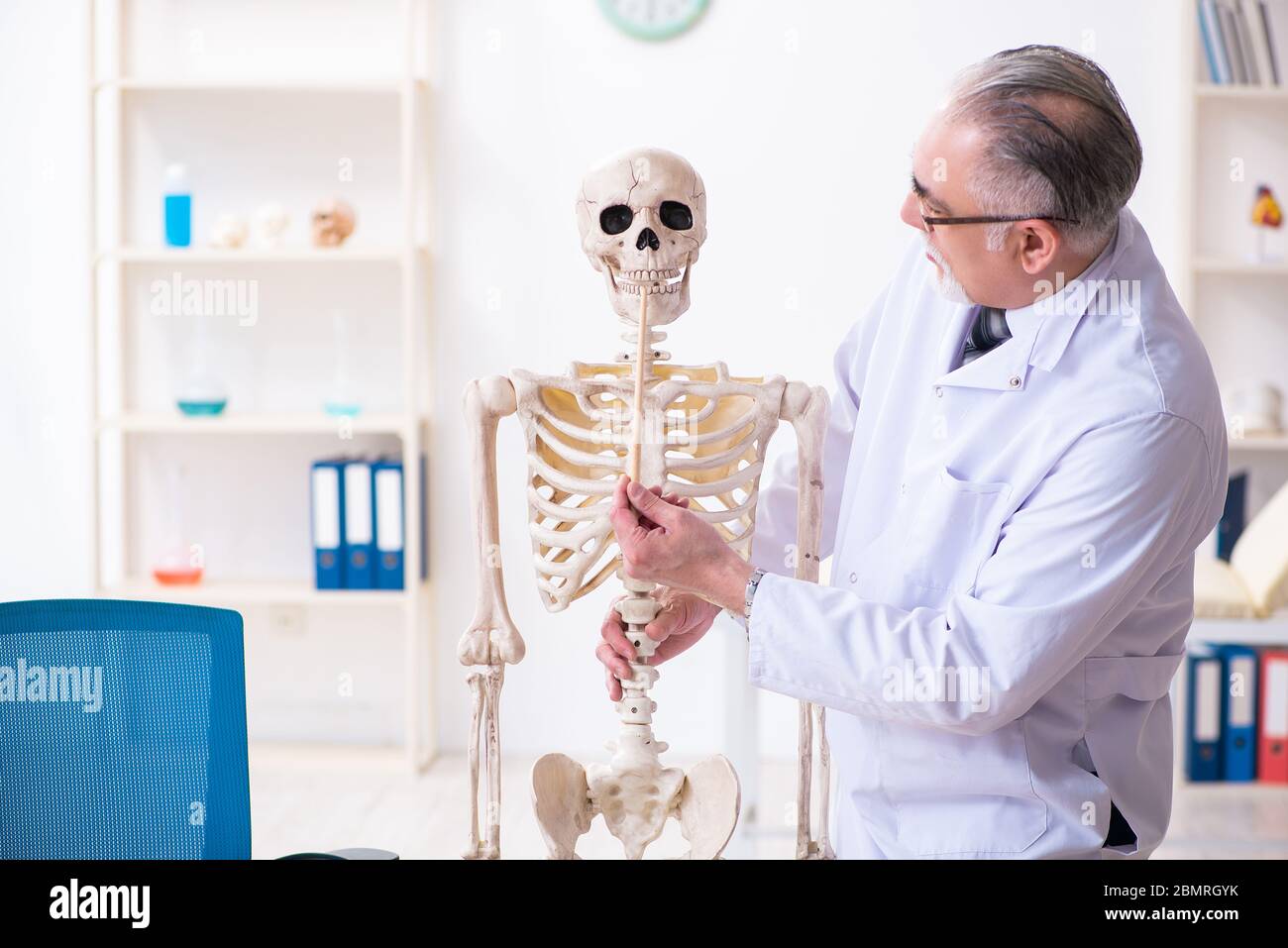 The aged male doctor with skeleton Stock Photo - Alamy