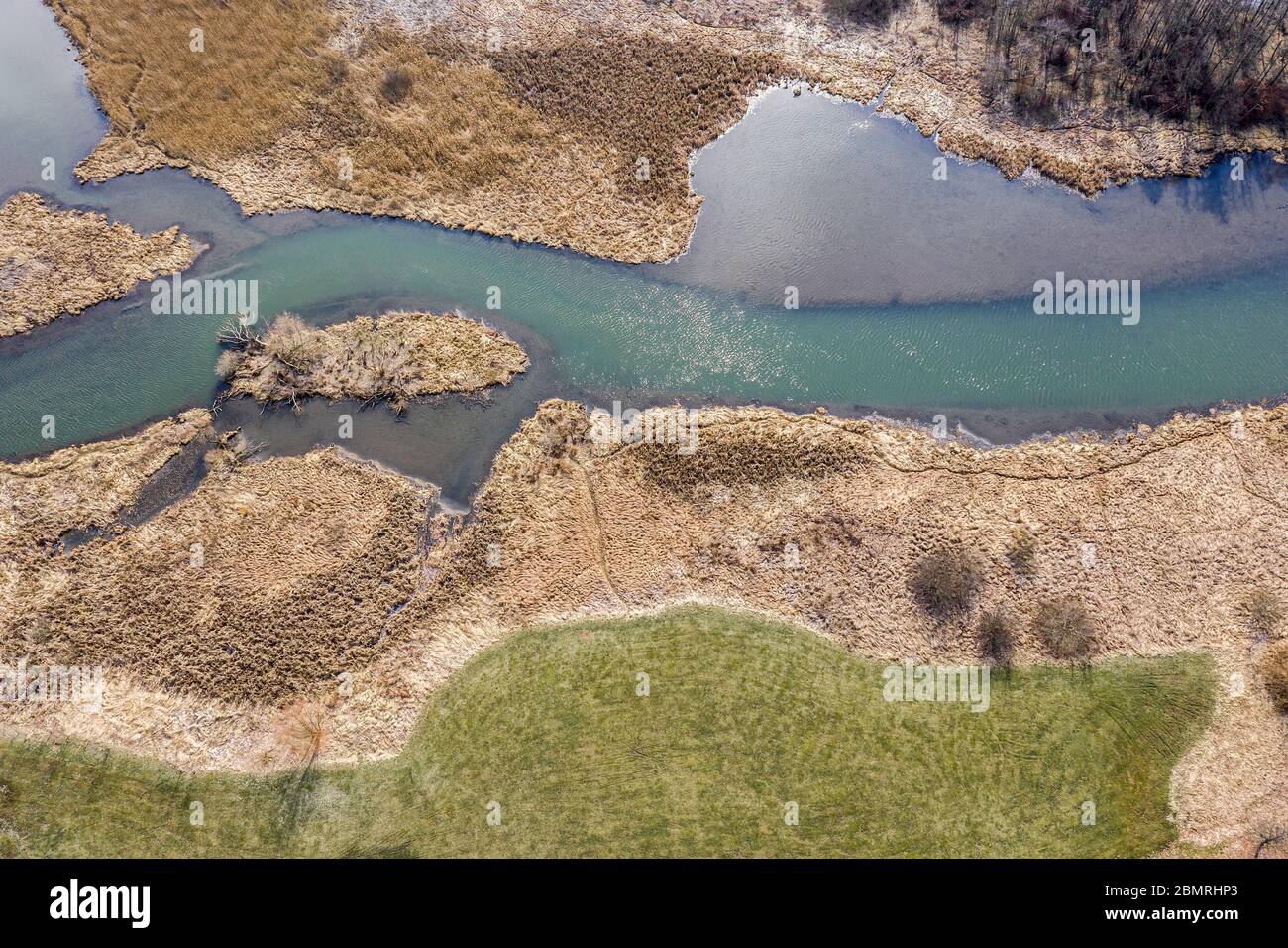 aerial drone view of winding river in green field and wetlands. bird's ...