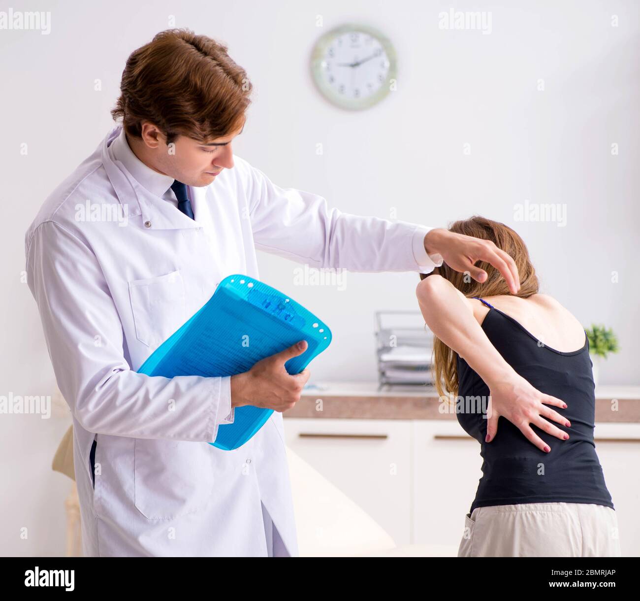 The female patient visiting young handsome doctor chiropractor Stock ...