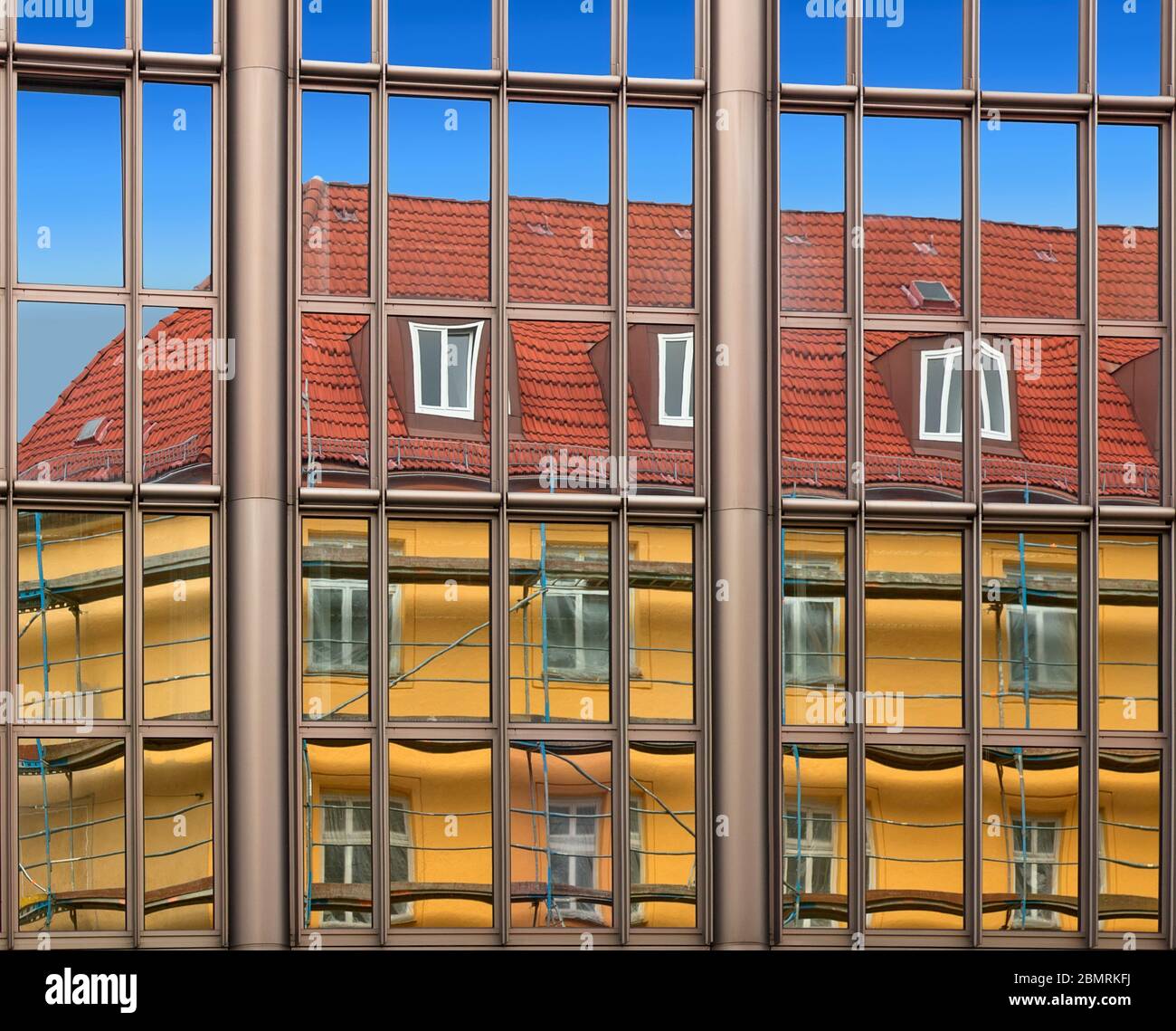 Old building architecture reflected in modern building. Front view of ...