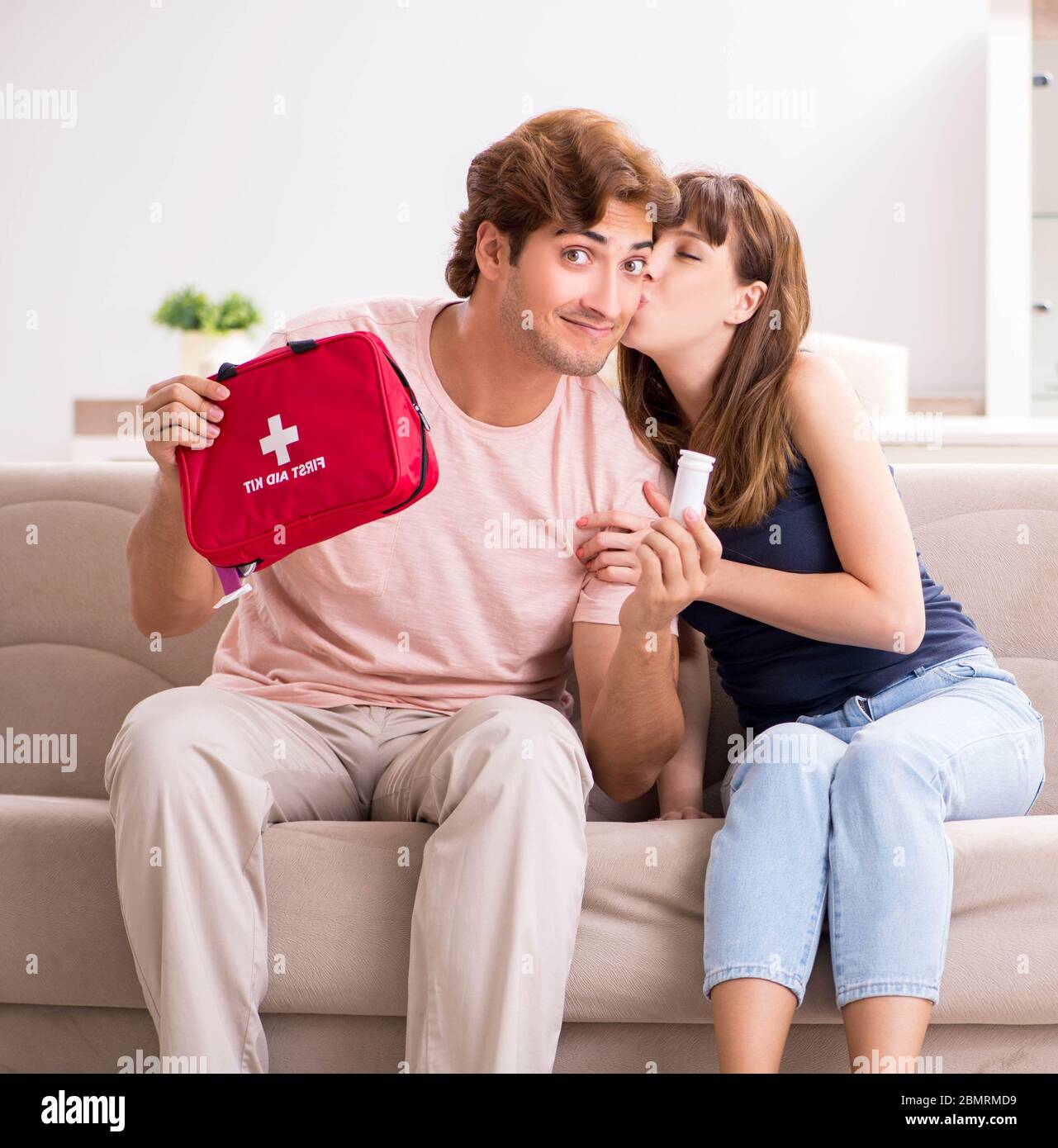 The young family getting treatment with first aid kit Stock Photo - Alamy