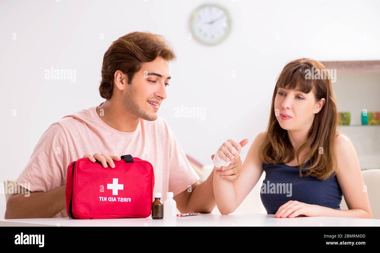 The young family getting treatment with first aid kit Stock Photo - Alamy