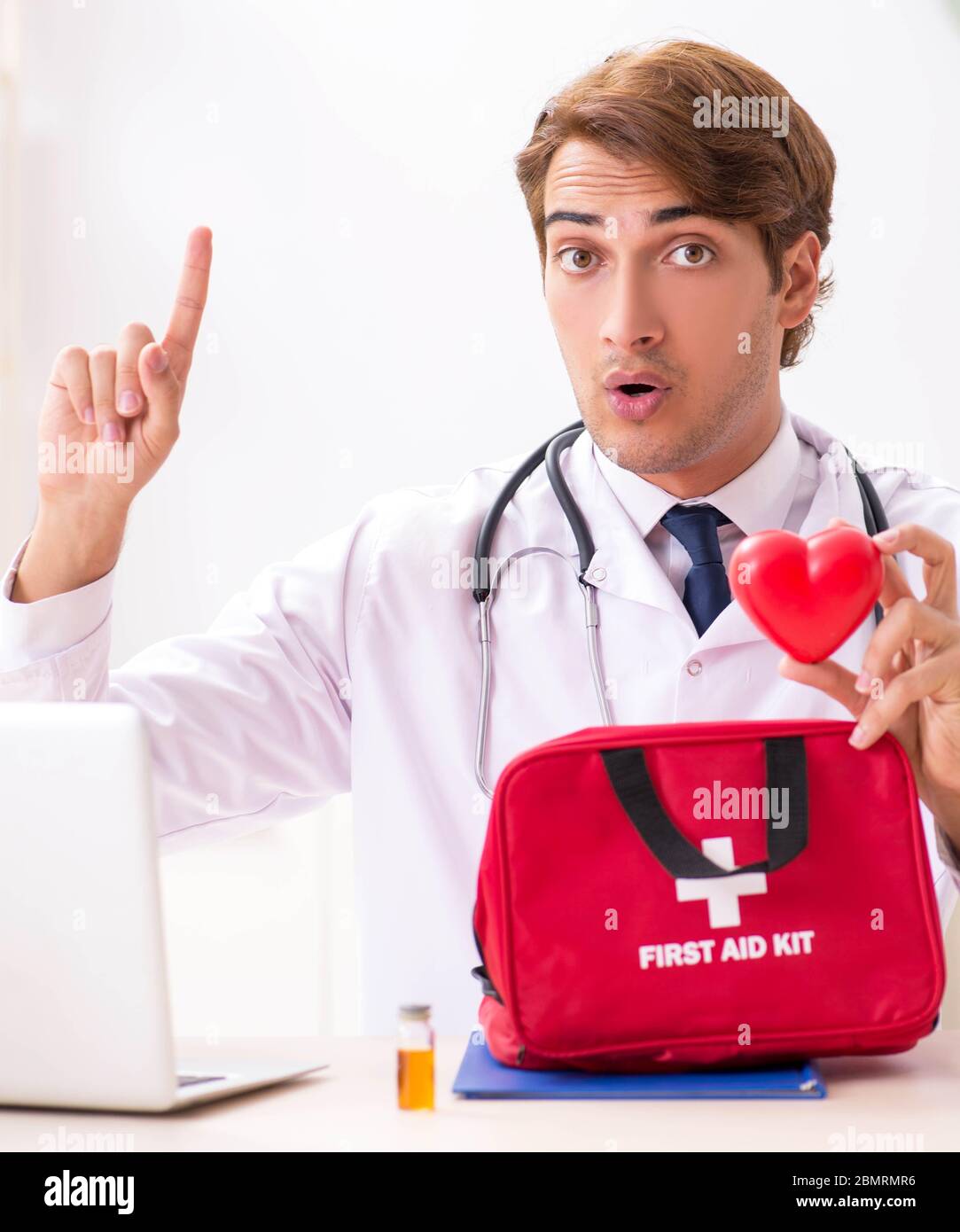 The young doctor with first aid kit in hospital Stock Photo - Alamy