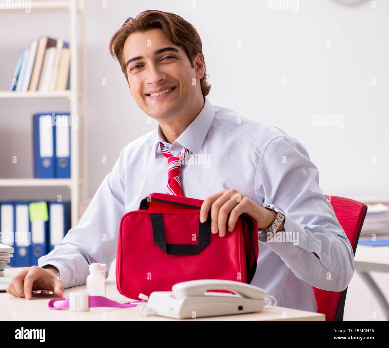 The man with first aid kit in the office Stock Photo - Alamy