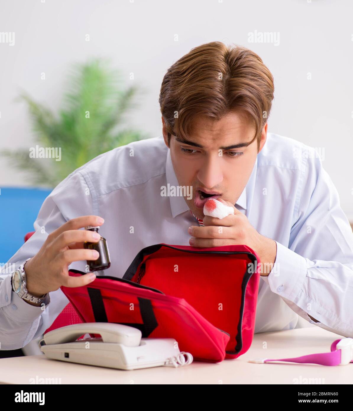 The man with first aid kit in the office Stock Photo - Alamy