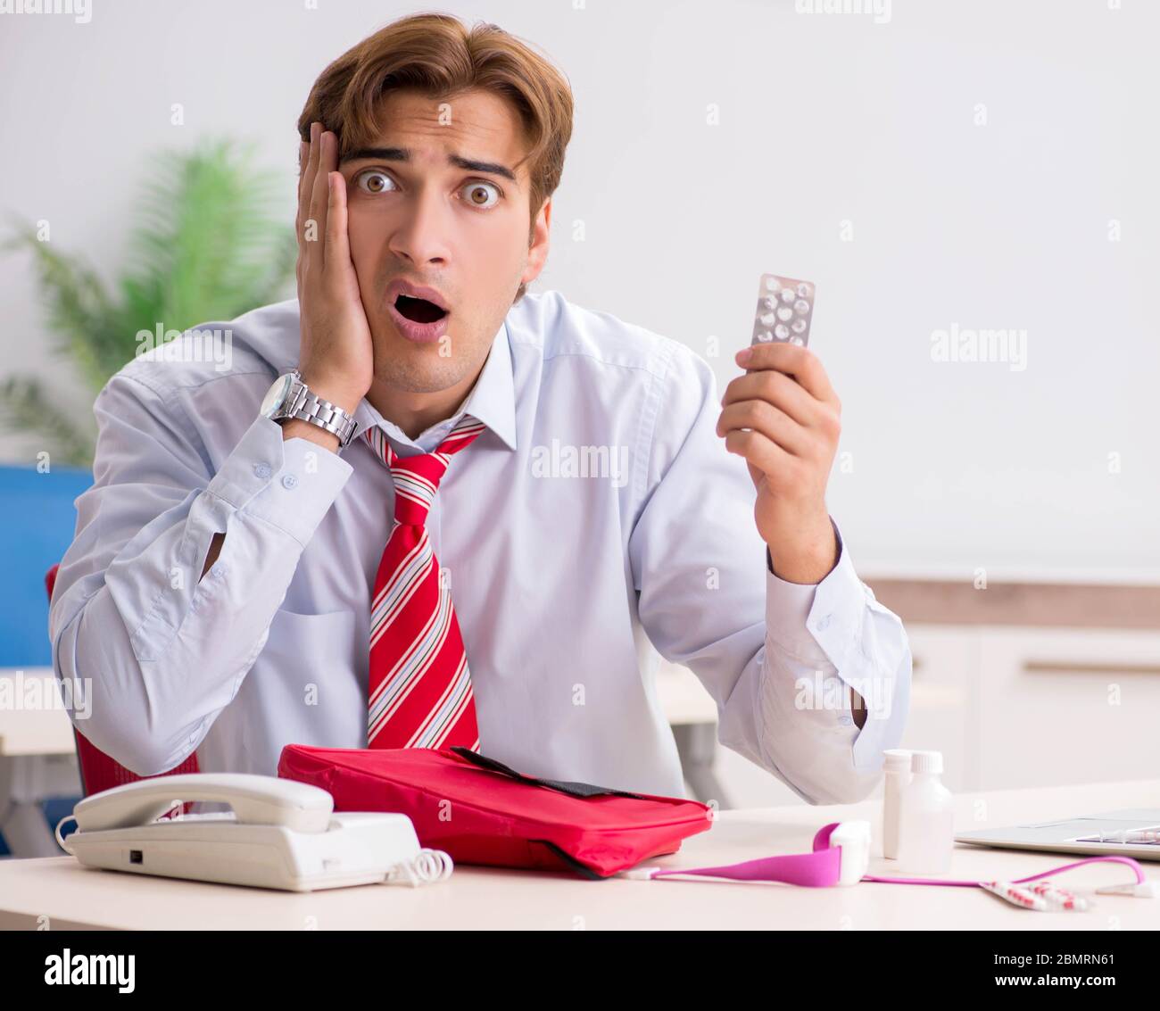 The man with first aid kit in the office Stock Photo - Alamy