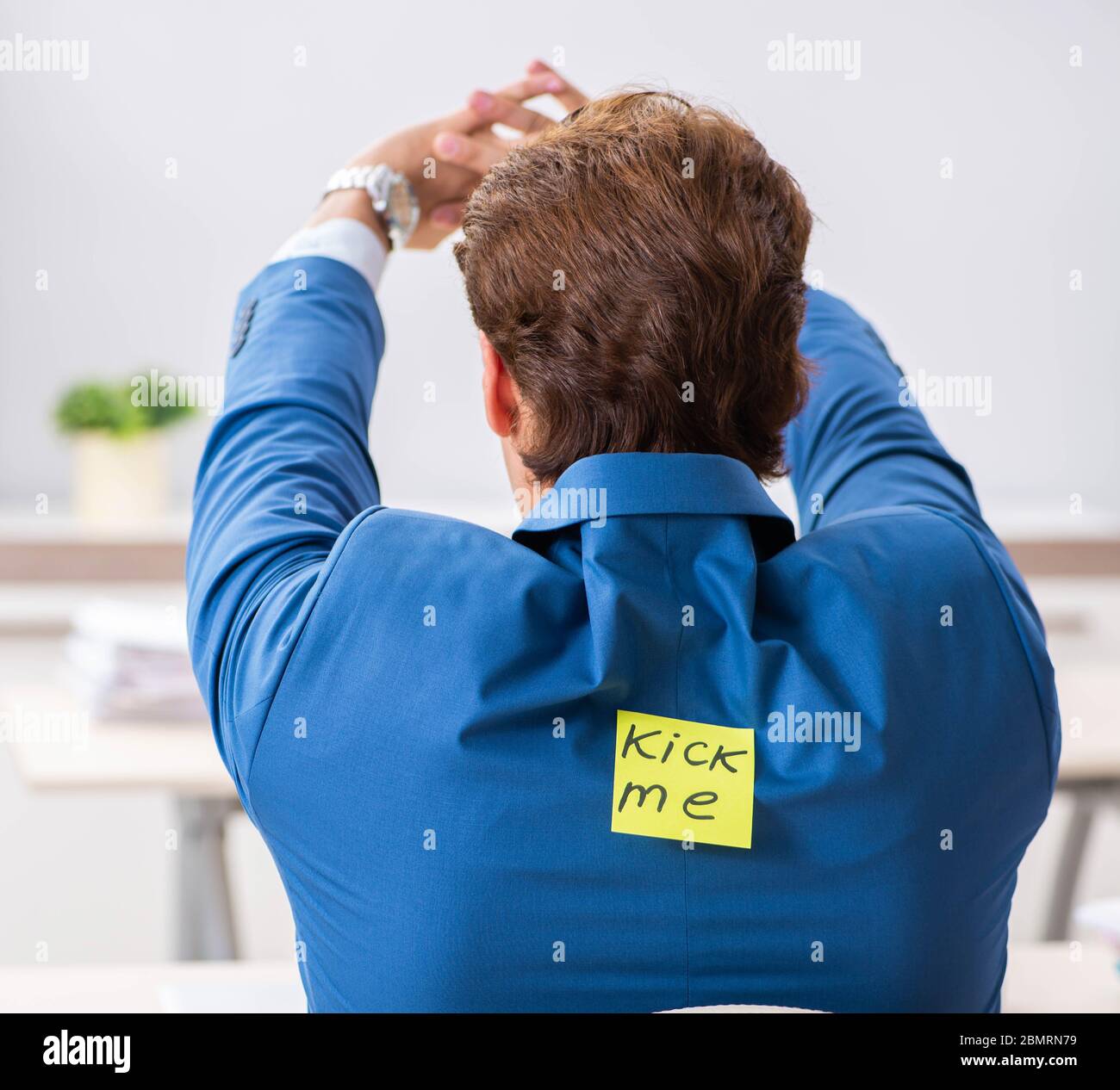 The office prank with kick me message on sticky note Stock Photo - Alamy