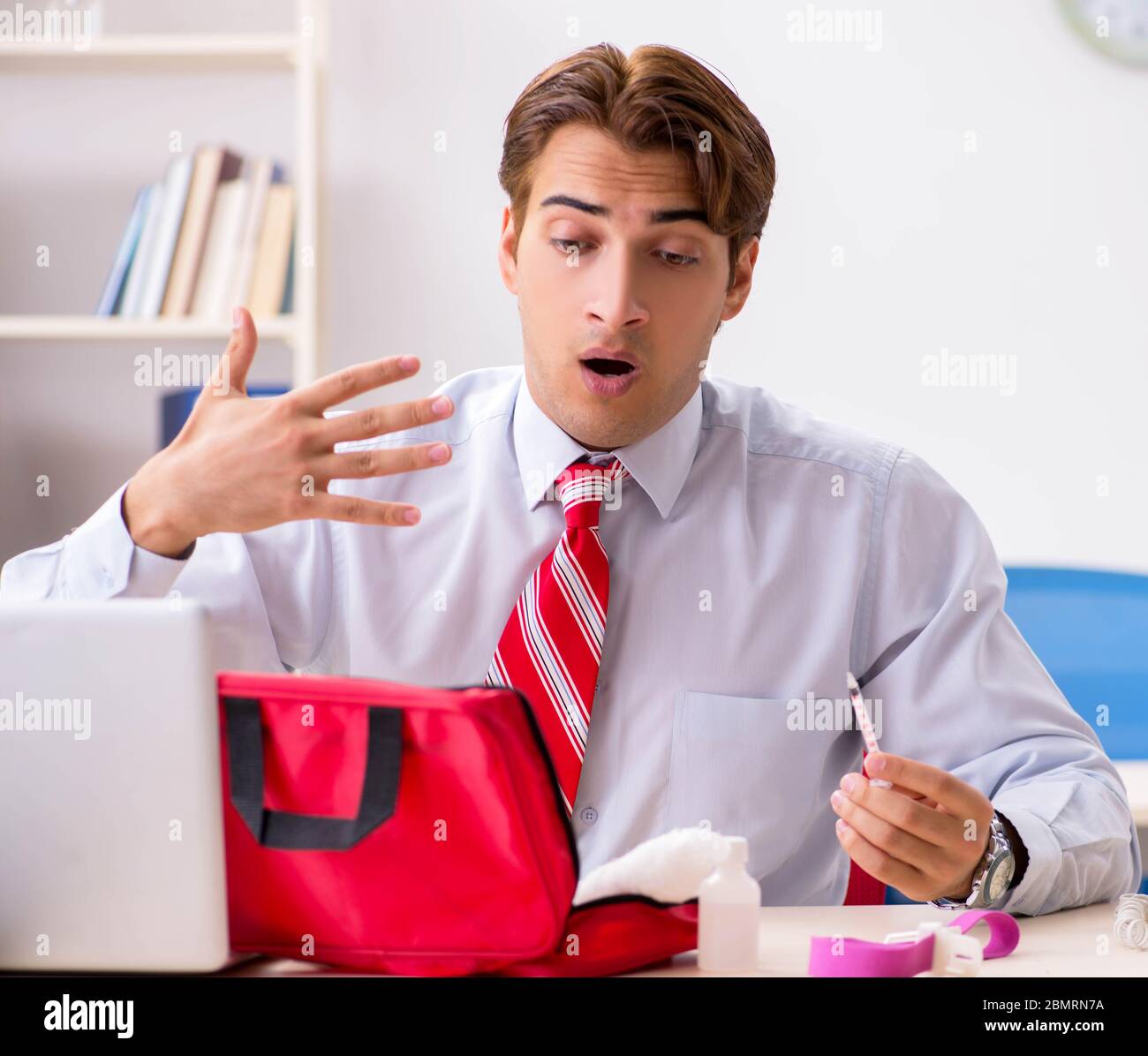 The man with first aid kit in the office Stock Photo - Alamy