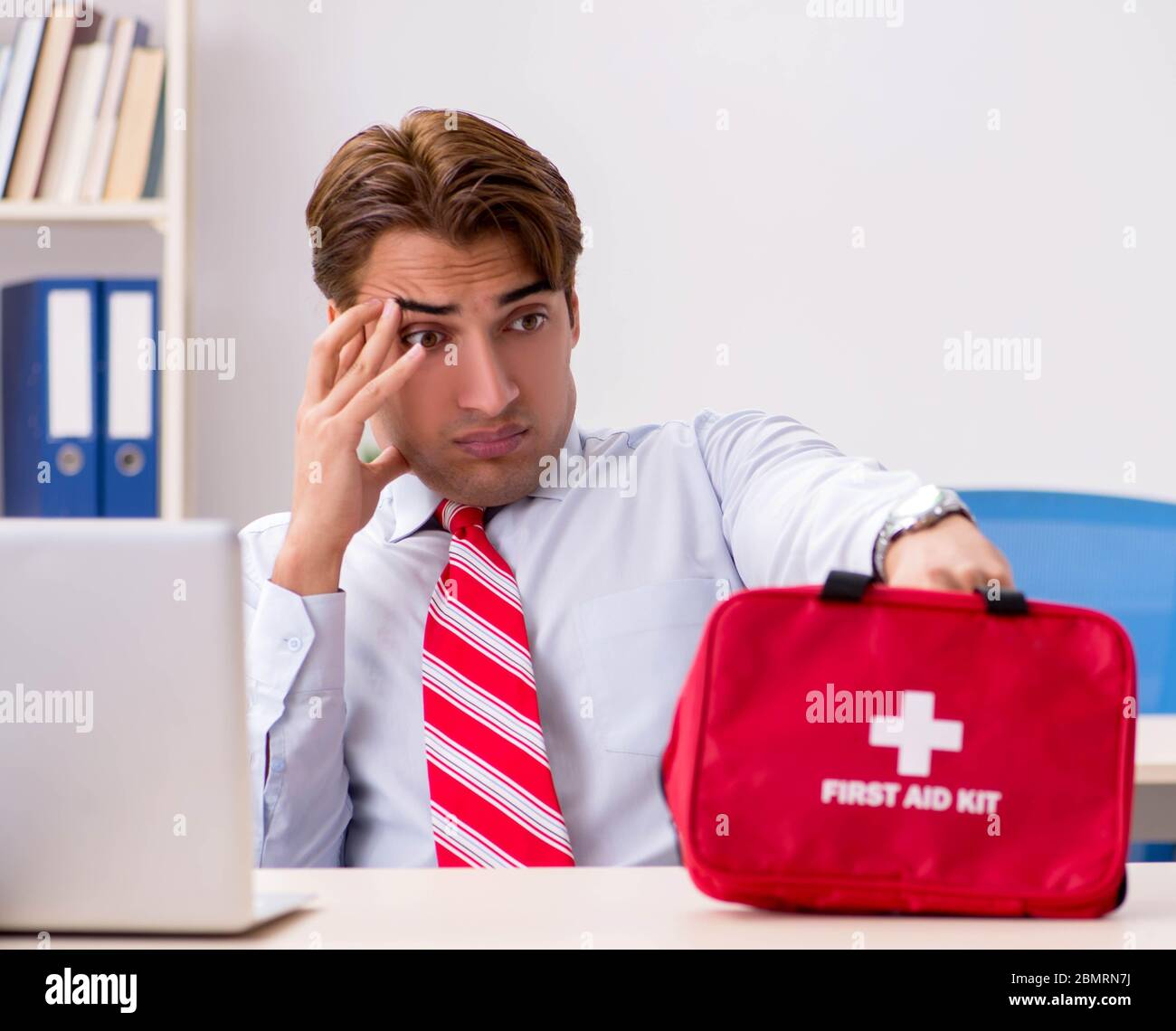 The man with first aid kit in the office Stock Photo - Alamy