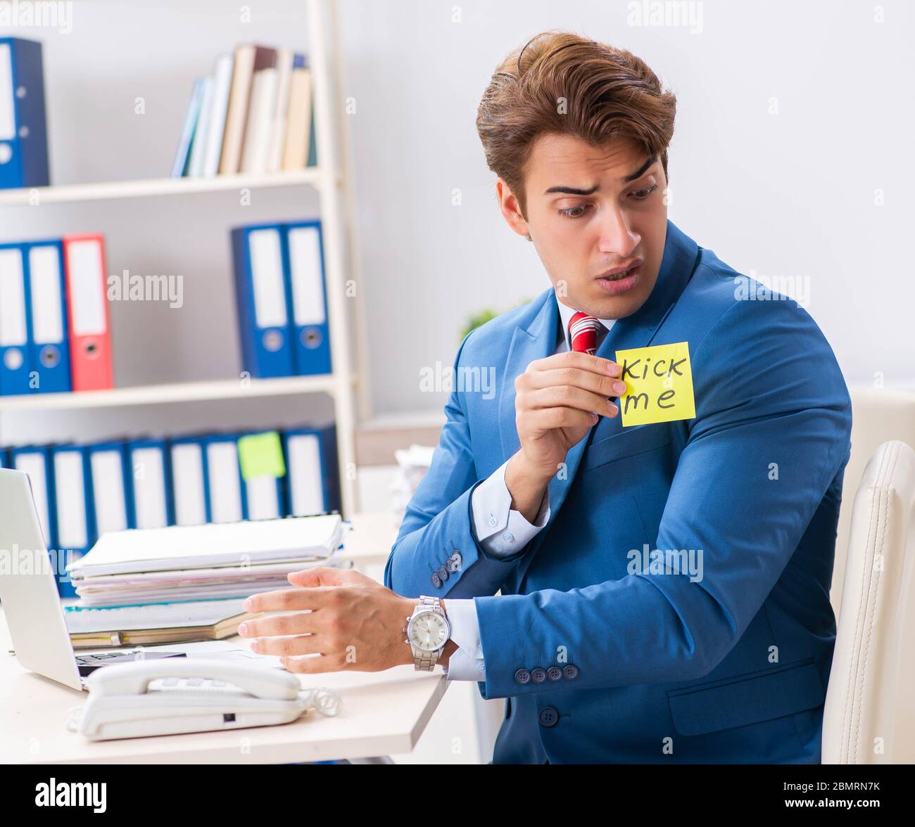 The office prank with kick me message on sticky note Stock Photo - Alamy