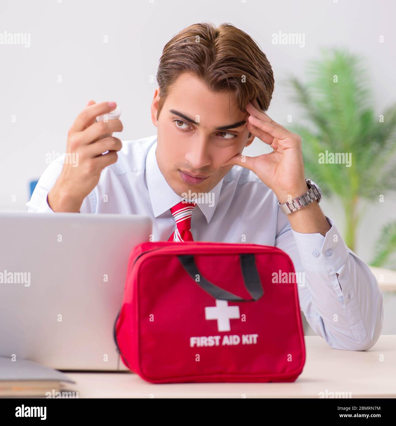 The man with first aid kit in the office Stock Photo - Alamy