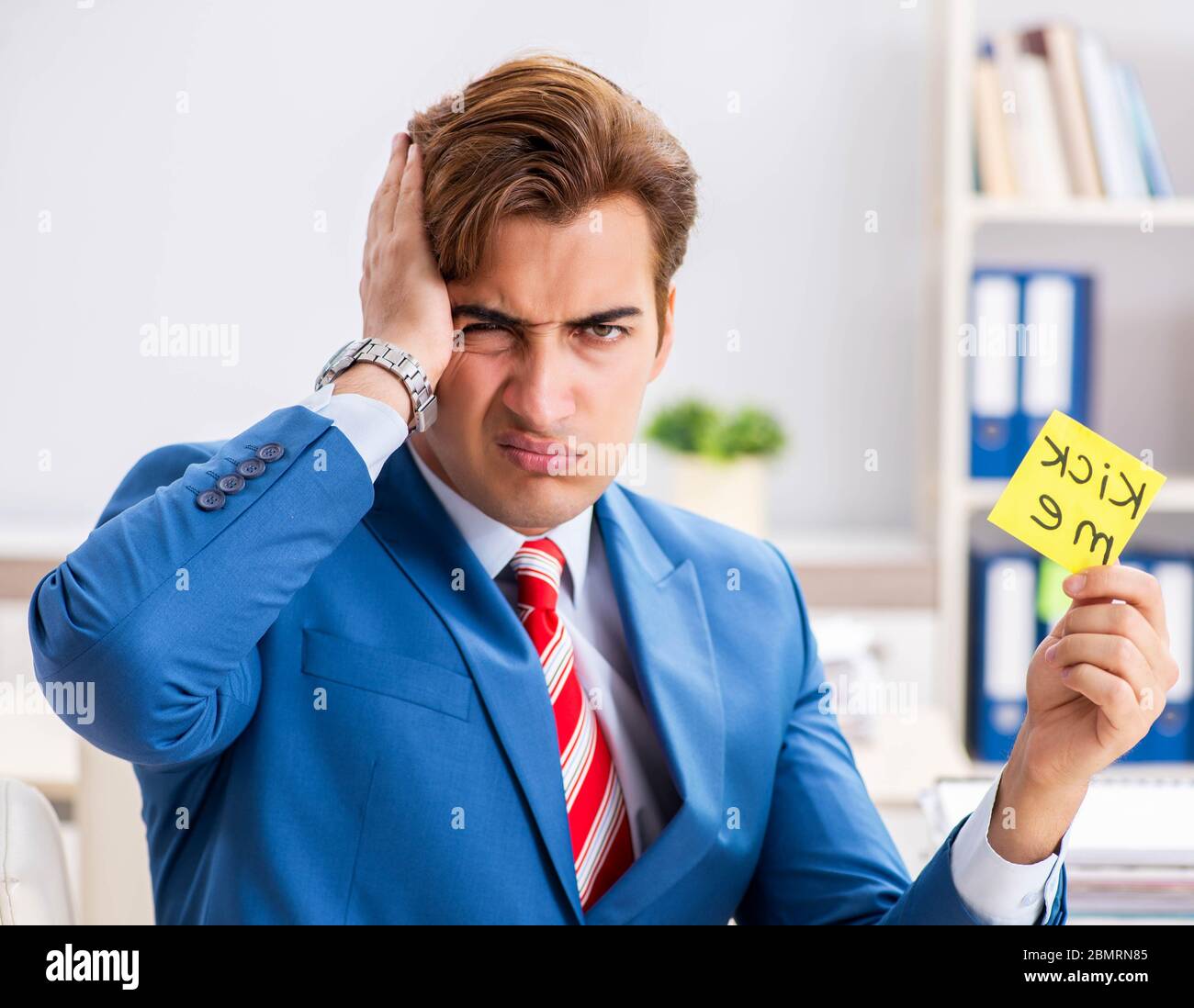 The office prank with kick me message on sticky note Stock Photo - Alamy