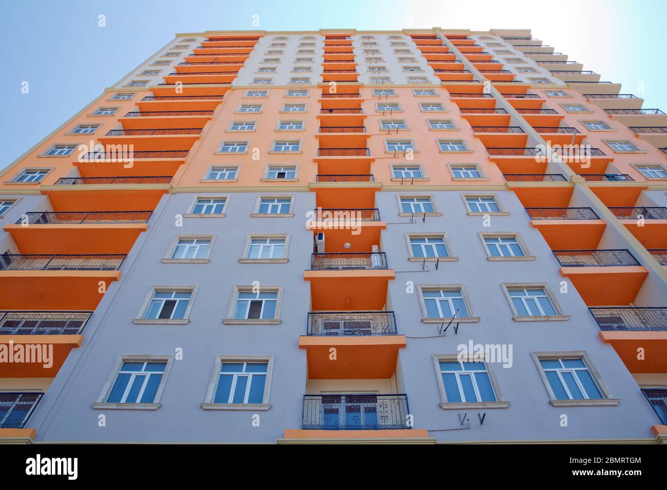 Facade of modern multi-storey new residential orange building near BAku ...