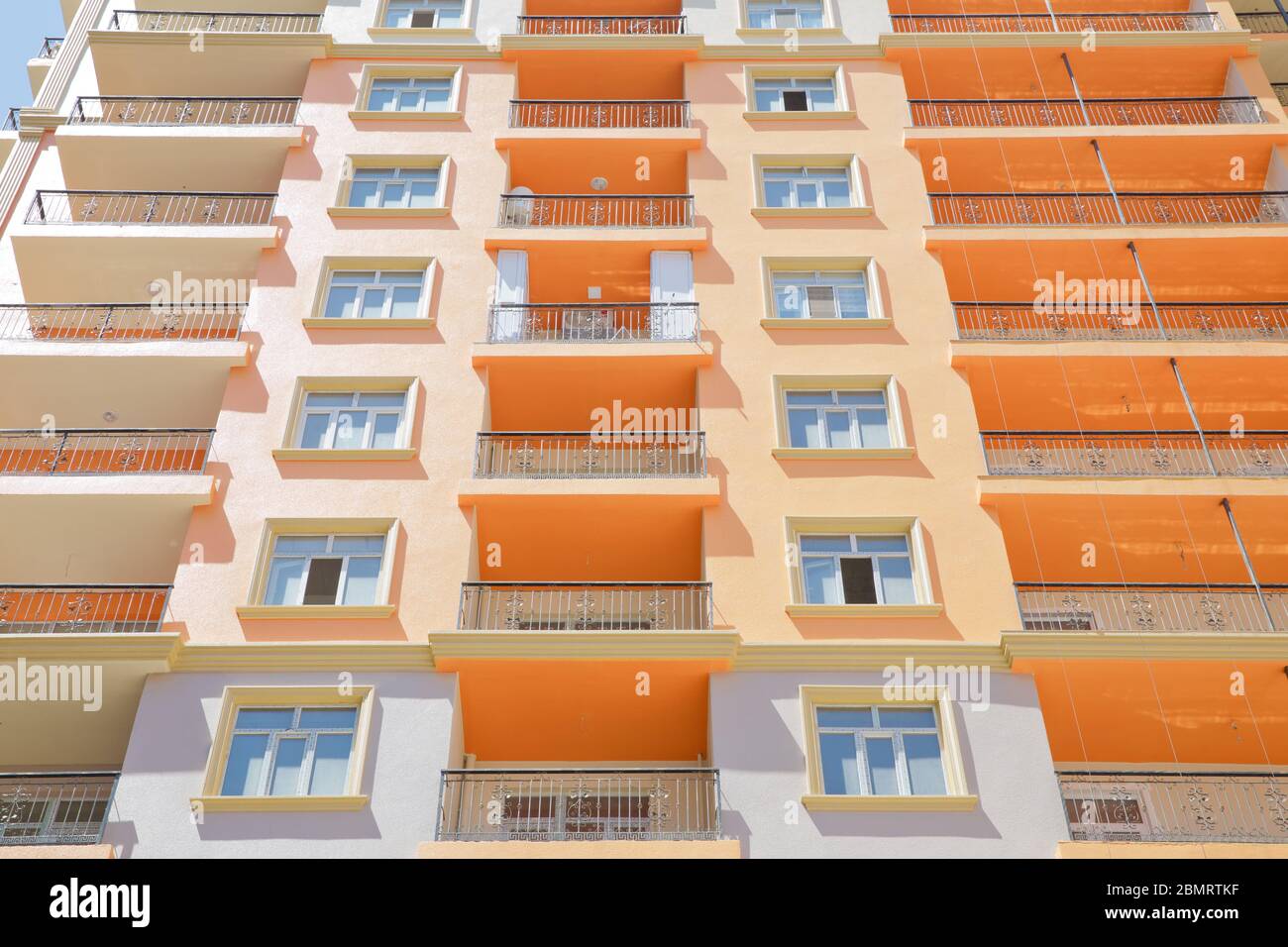 Facade of modern multi-storey new residential orange building near BAku ...
