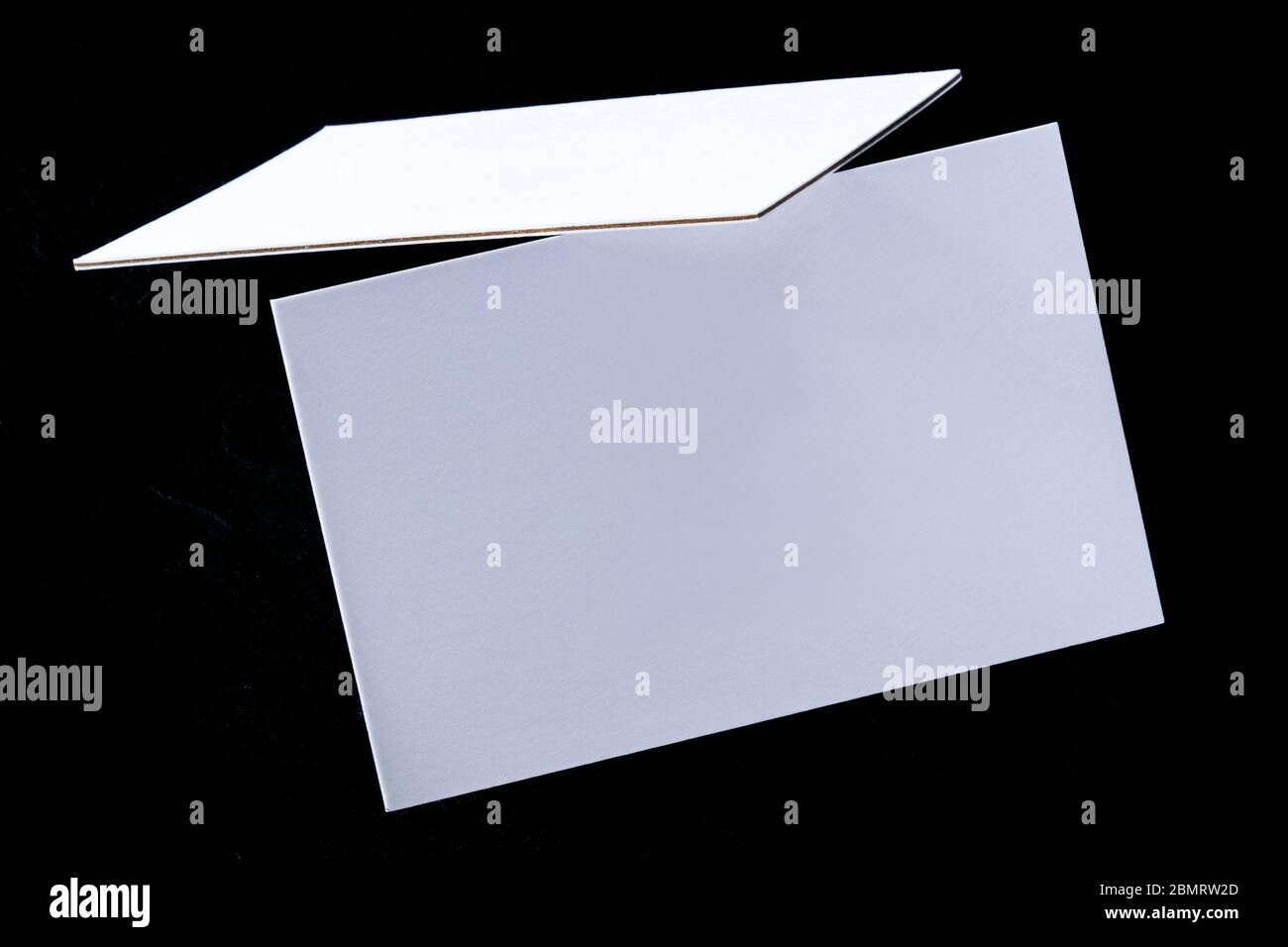 White 3-ply business cards, floating on a black background, a mock-up ...