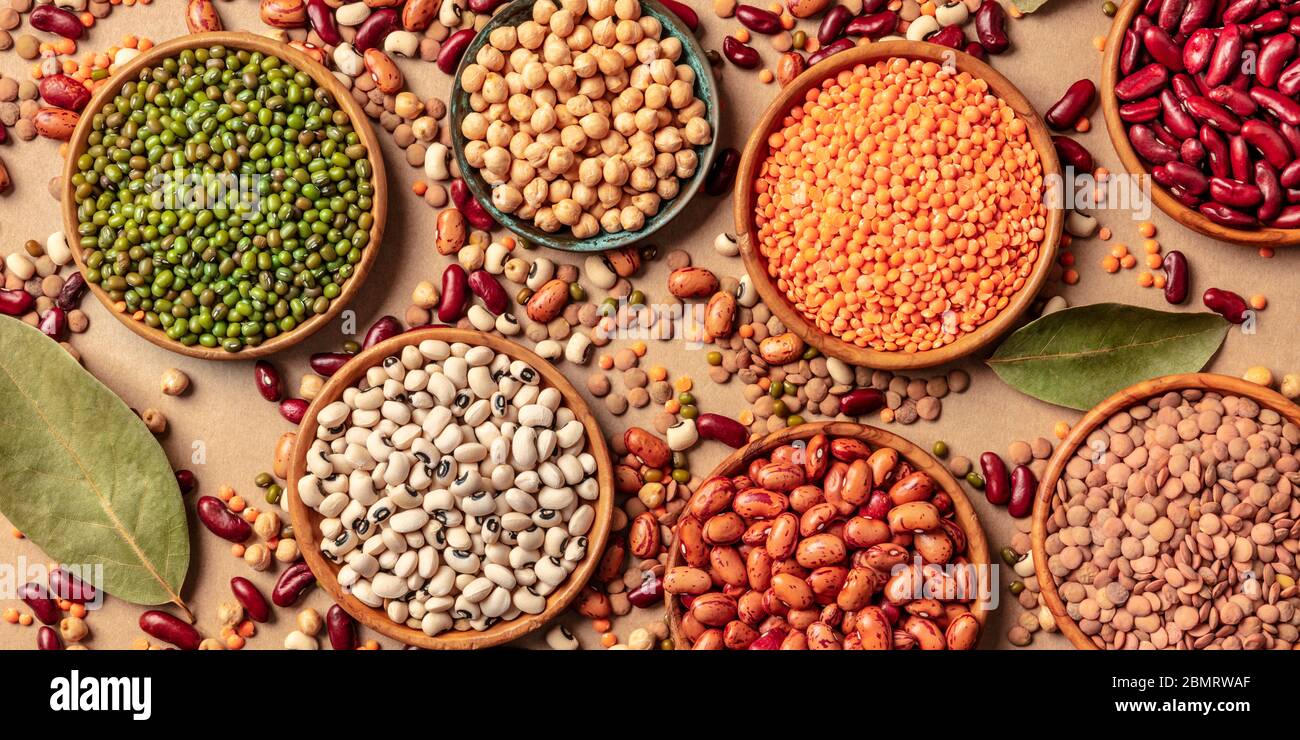 Legumes assortment, a flat lay panorama on a brown background. Lentils ...
