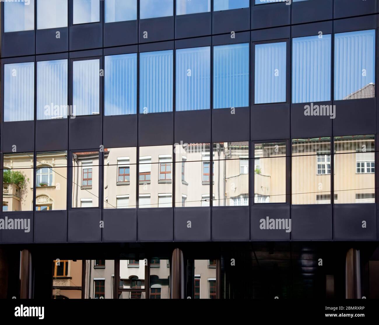Old building architecture reflected in modern building. Front view of ...