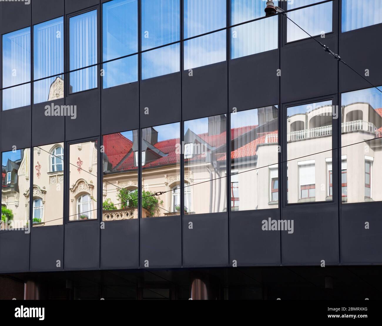 Old building architecture reflected in modern building. Front view of ...