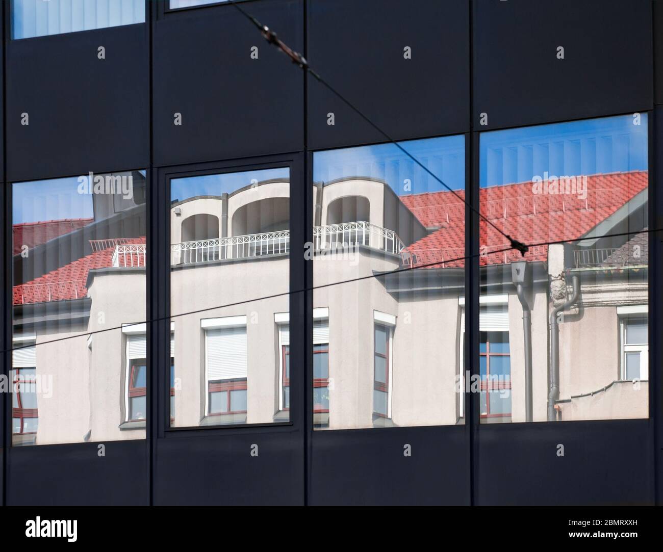 Old building architecture reflected in modern building. Front view of ...