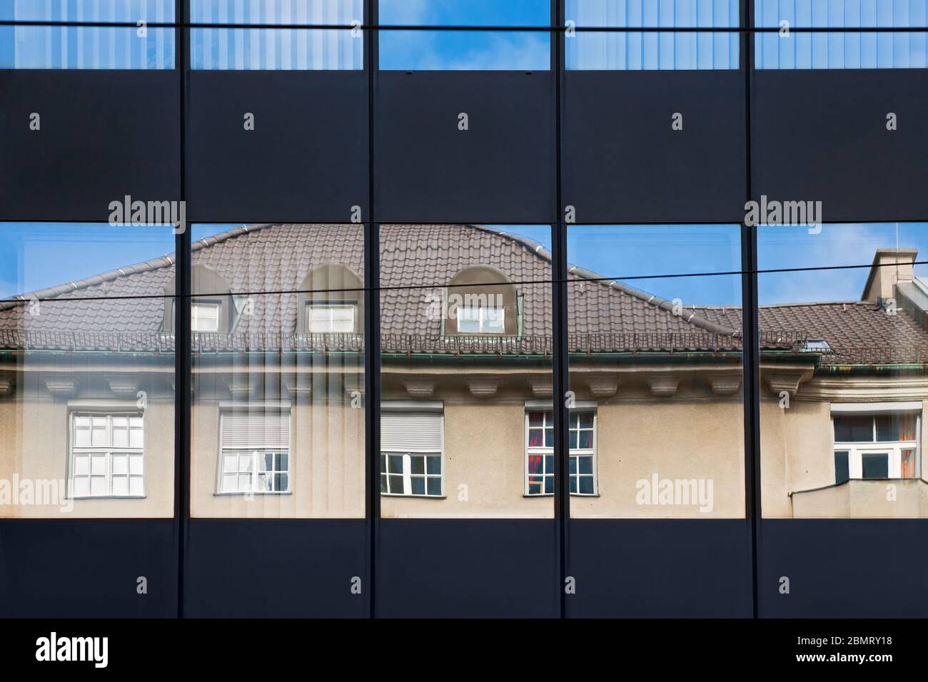 Old building architecture reflected in modern building. Front view of ...