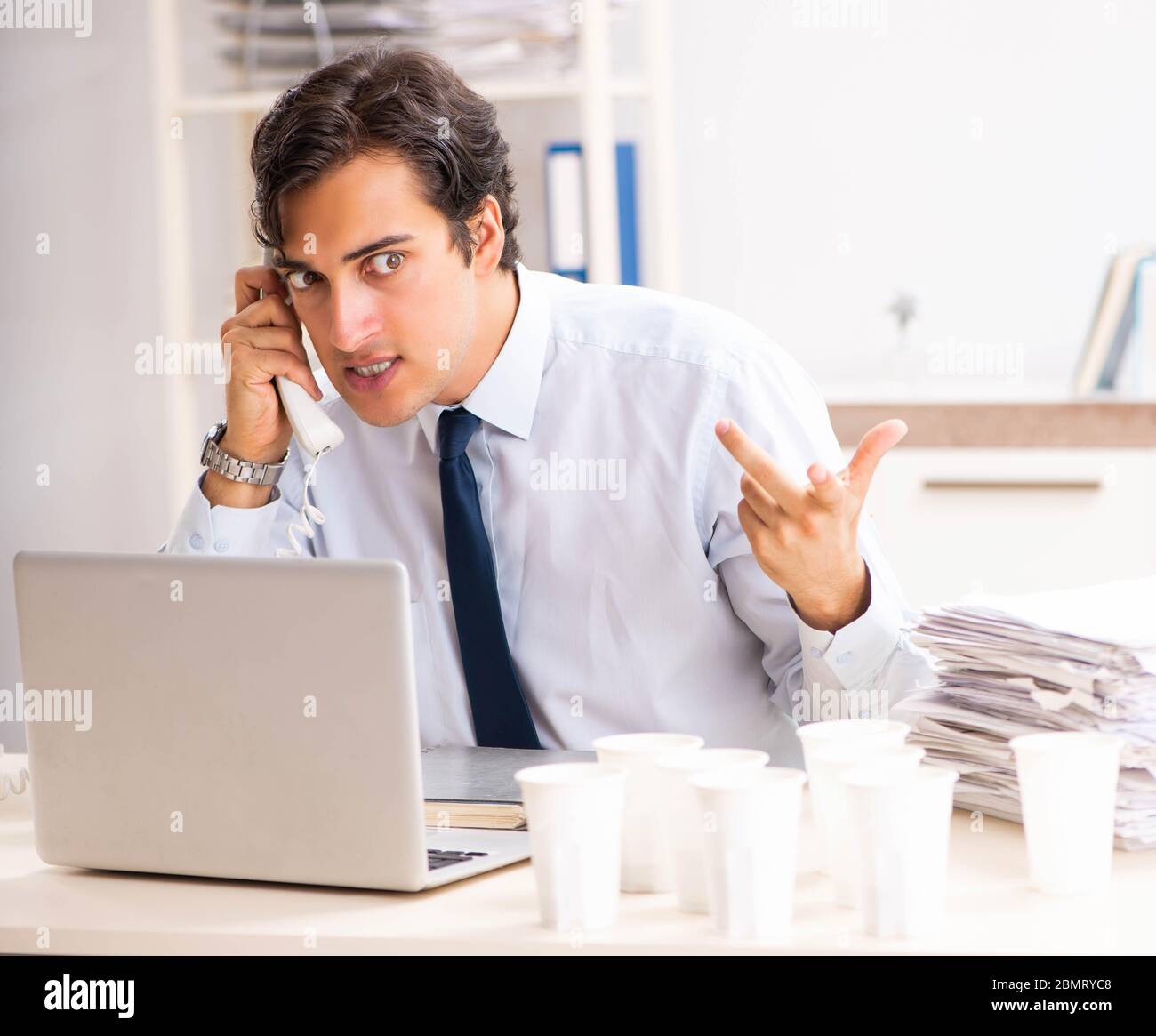 The young employee addicted to coffee Stock Photo - Alamy