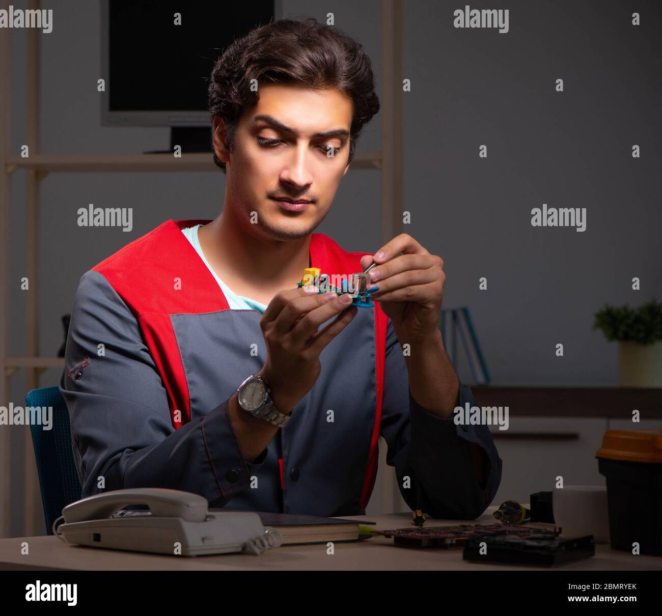 The young handsome repairman repairing computer Stock Photo - Alamy