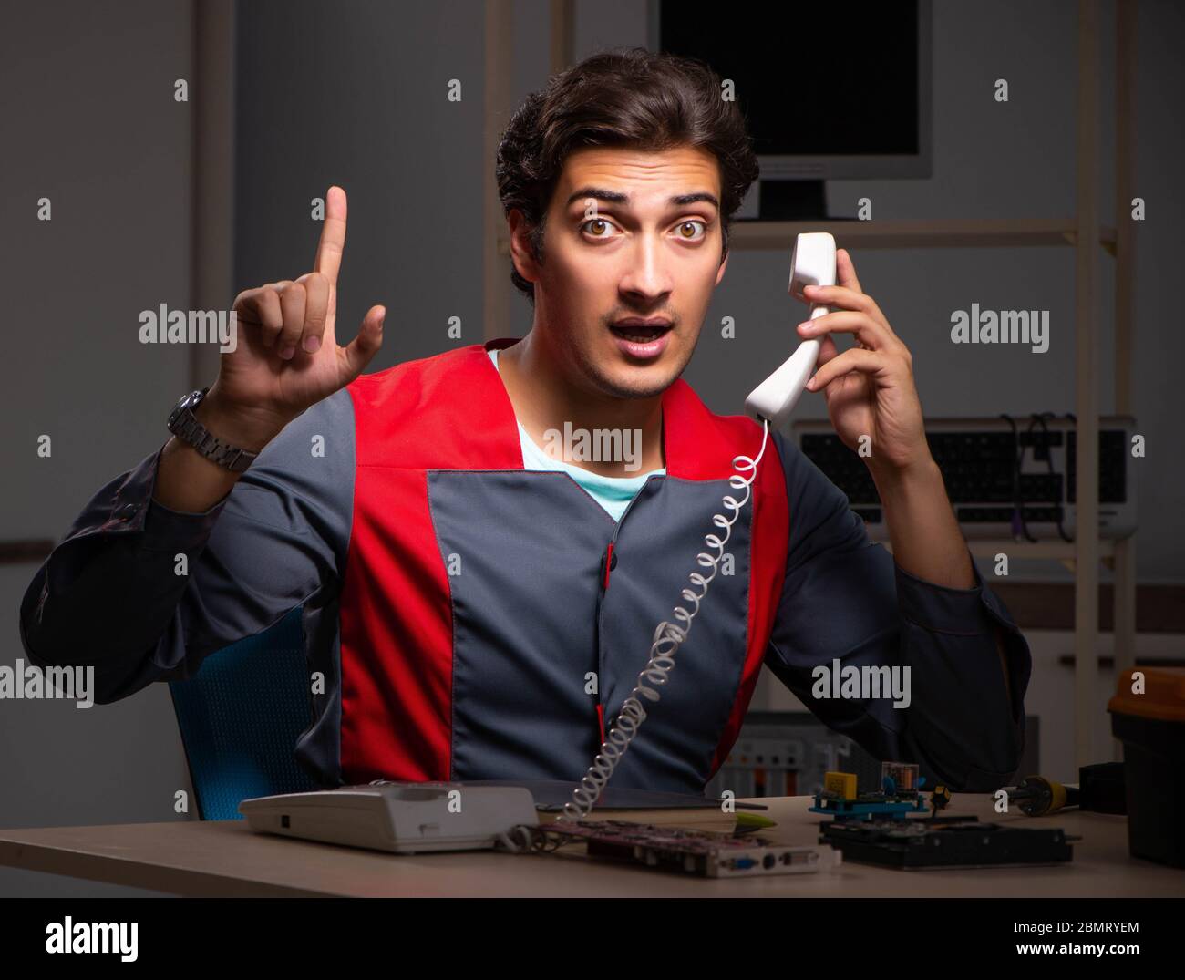 The young handsome repairman repairing computer Stock Photo - Alamy